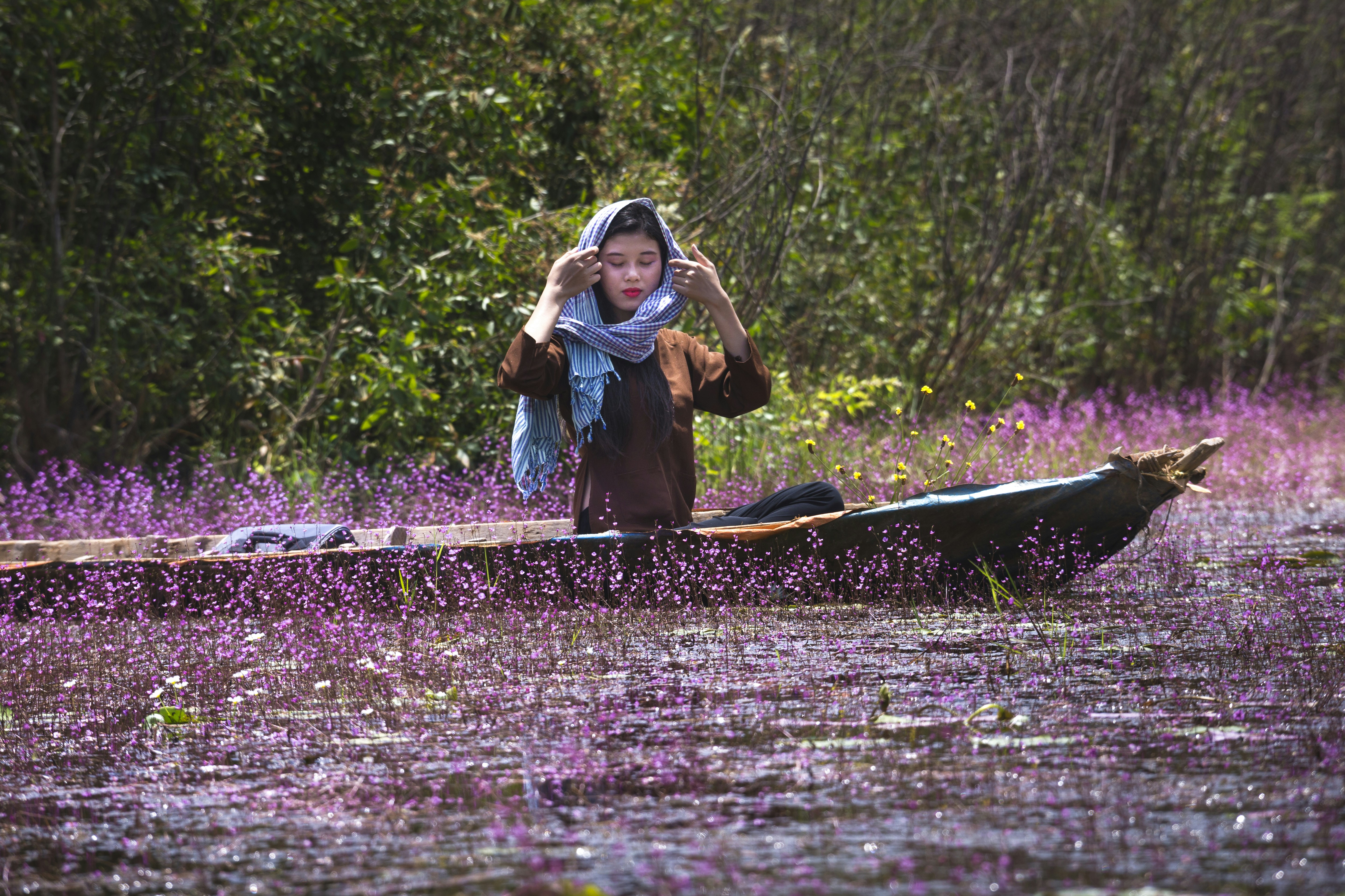 Scarved Figure in a Pink-Flowered Waterway: Quiet Contemplation in a Narrow Boat
