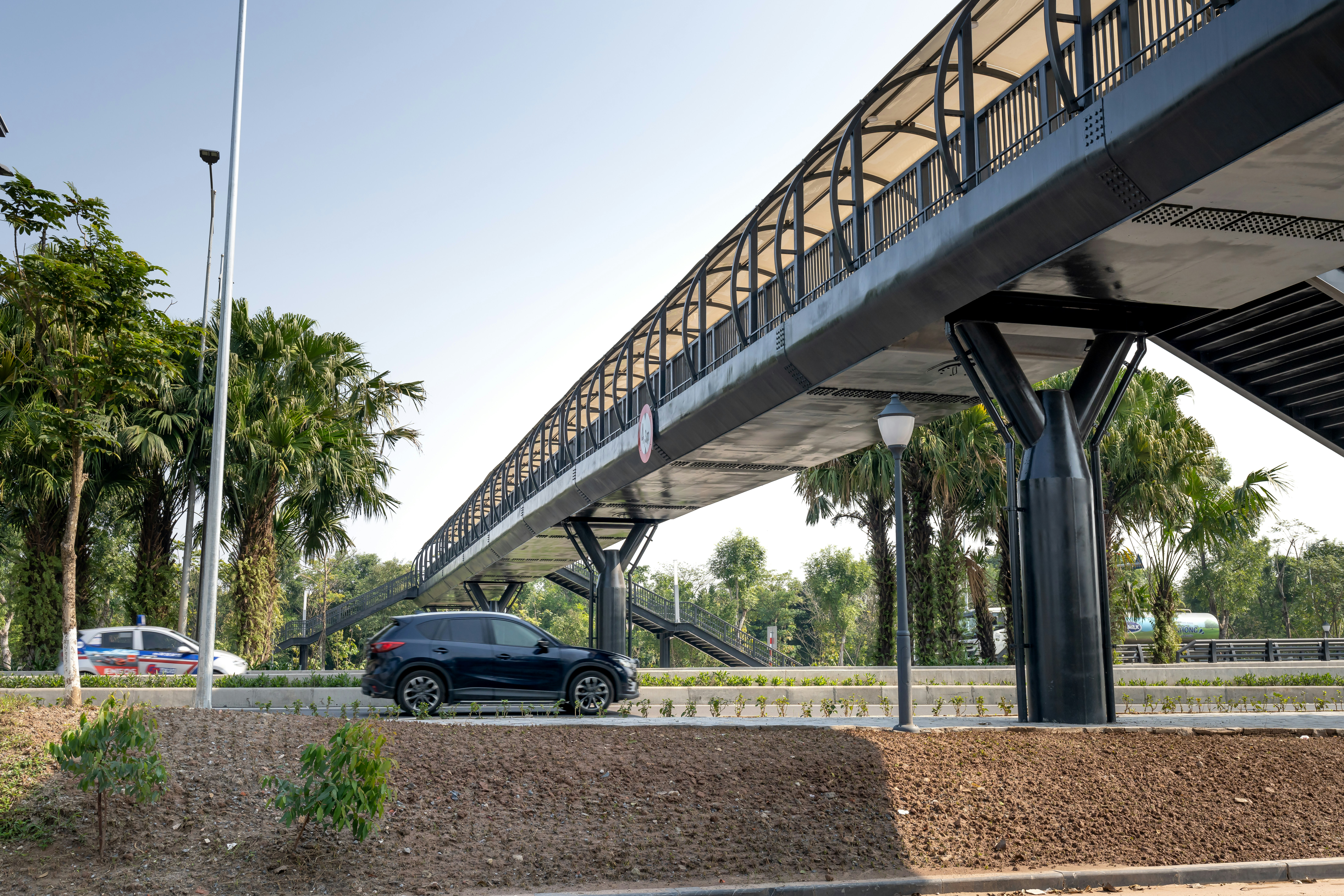 A blue car is driving under a bridge photo – Free Road Image on Unsplash
