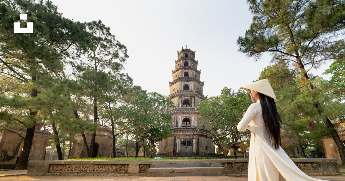 Una Mujer Con Un Vestido Blanco Y Sombrero Sentada En El Suelo Foto
