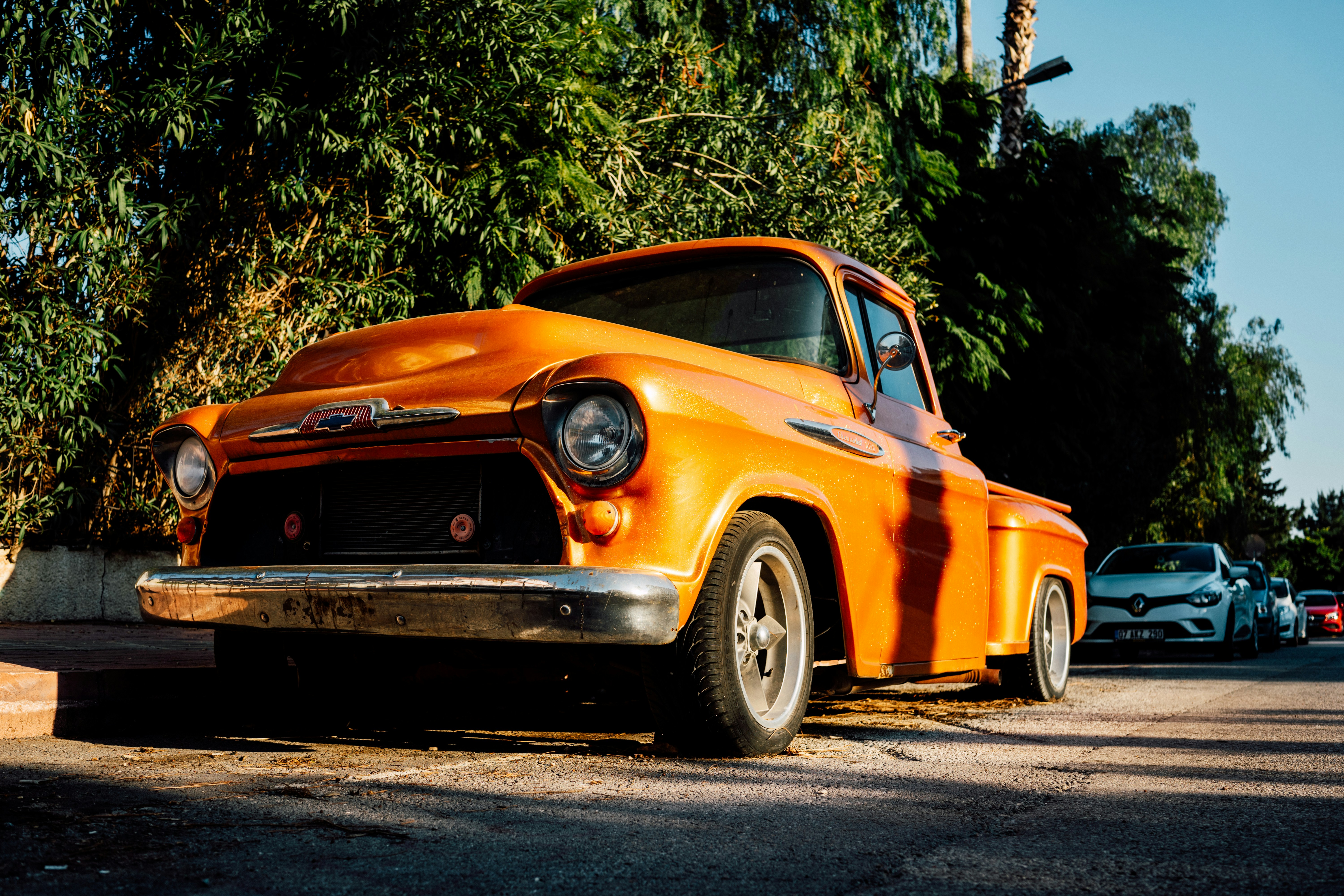 Sun-Warmed Orange Vintage Pickup Anchors a Quiet Street