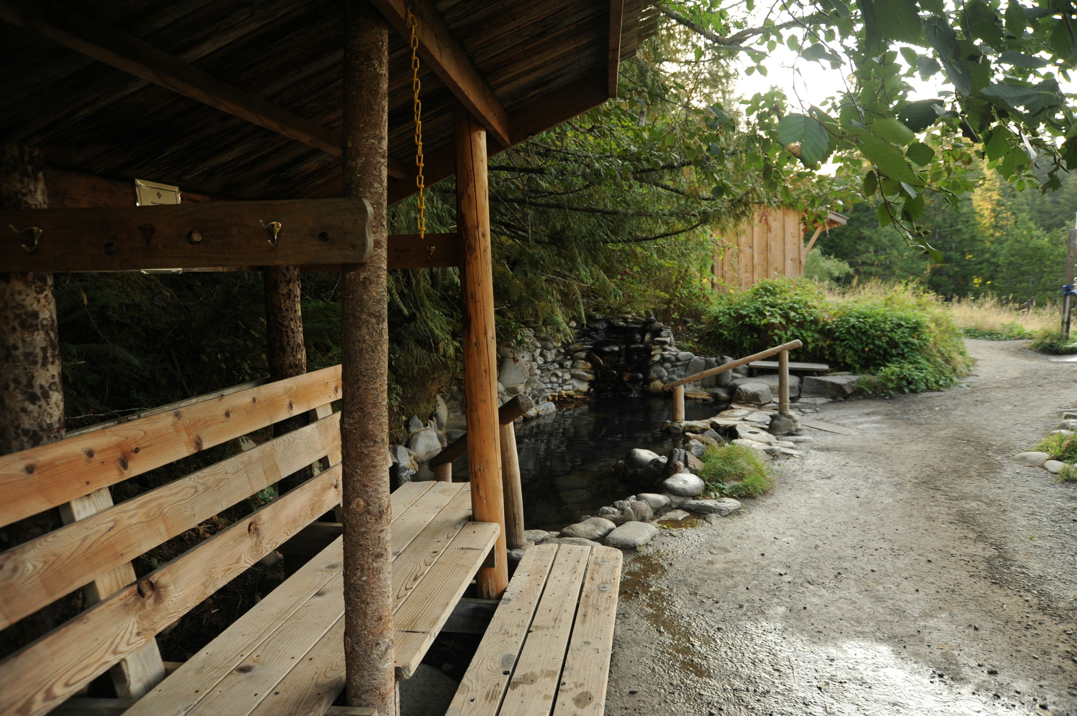 Un banco de madera sentado encima de un camino de tierra foto – Imagen ...