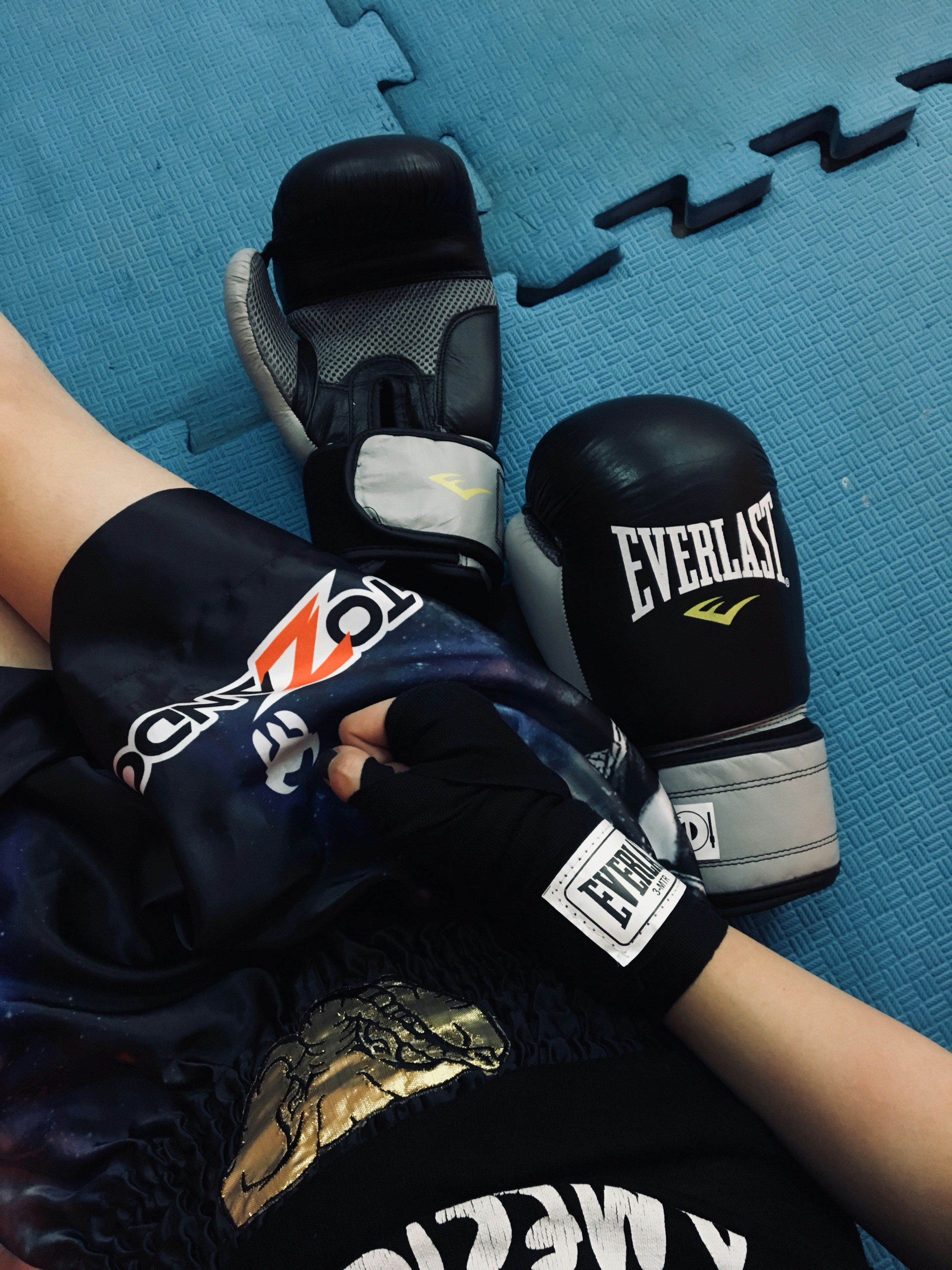 A pair of boxing gloves laying on top of a blue floor photo – Free ...