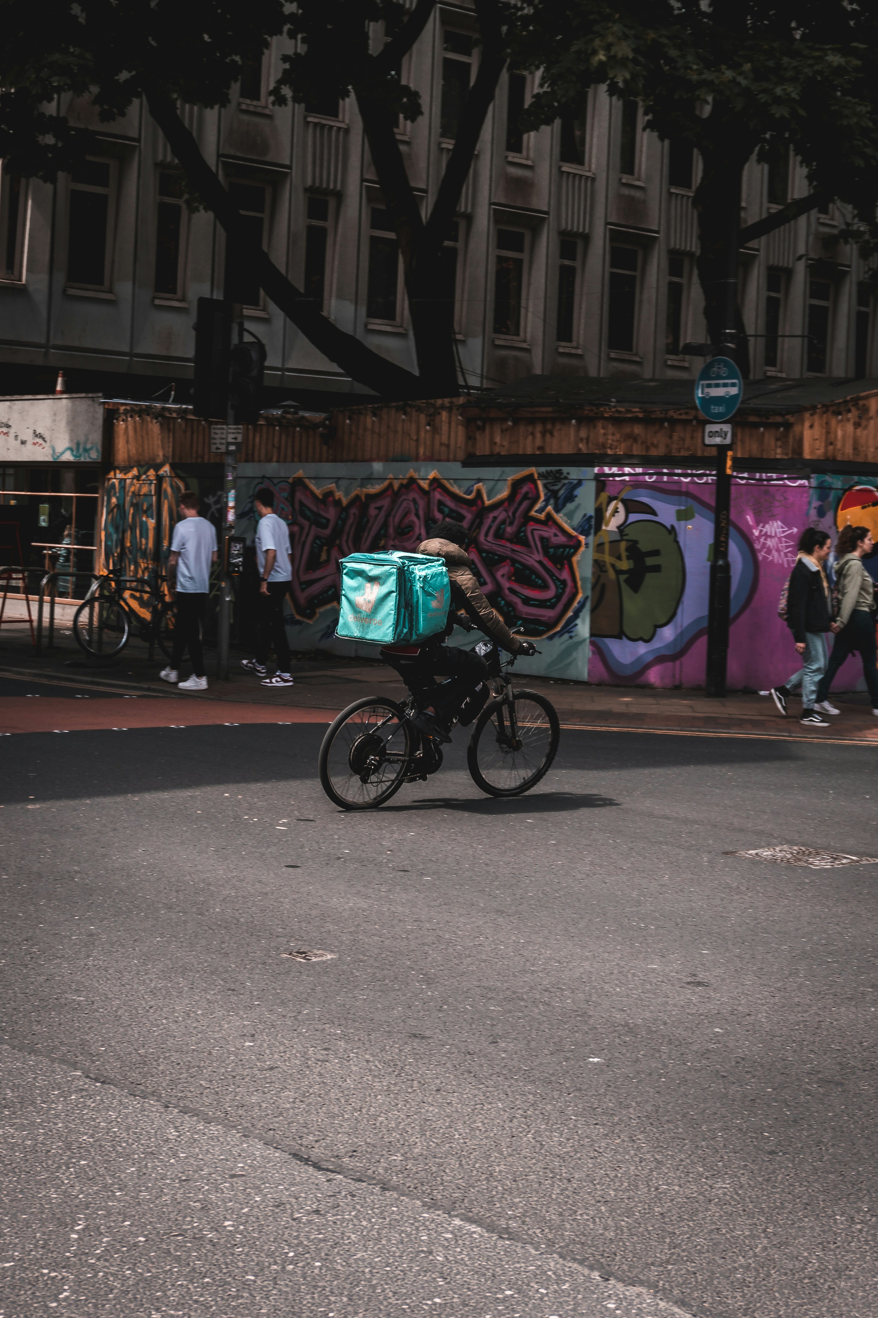 Teal-Cargo Courier Navigates Graffiti Alley at Dusk