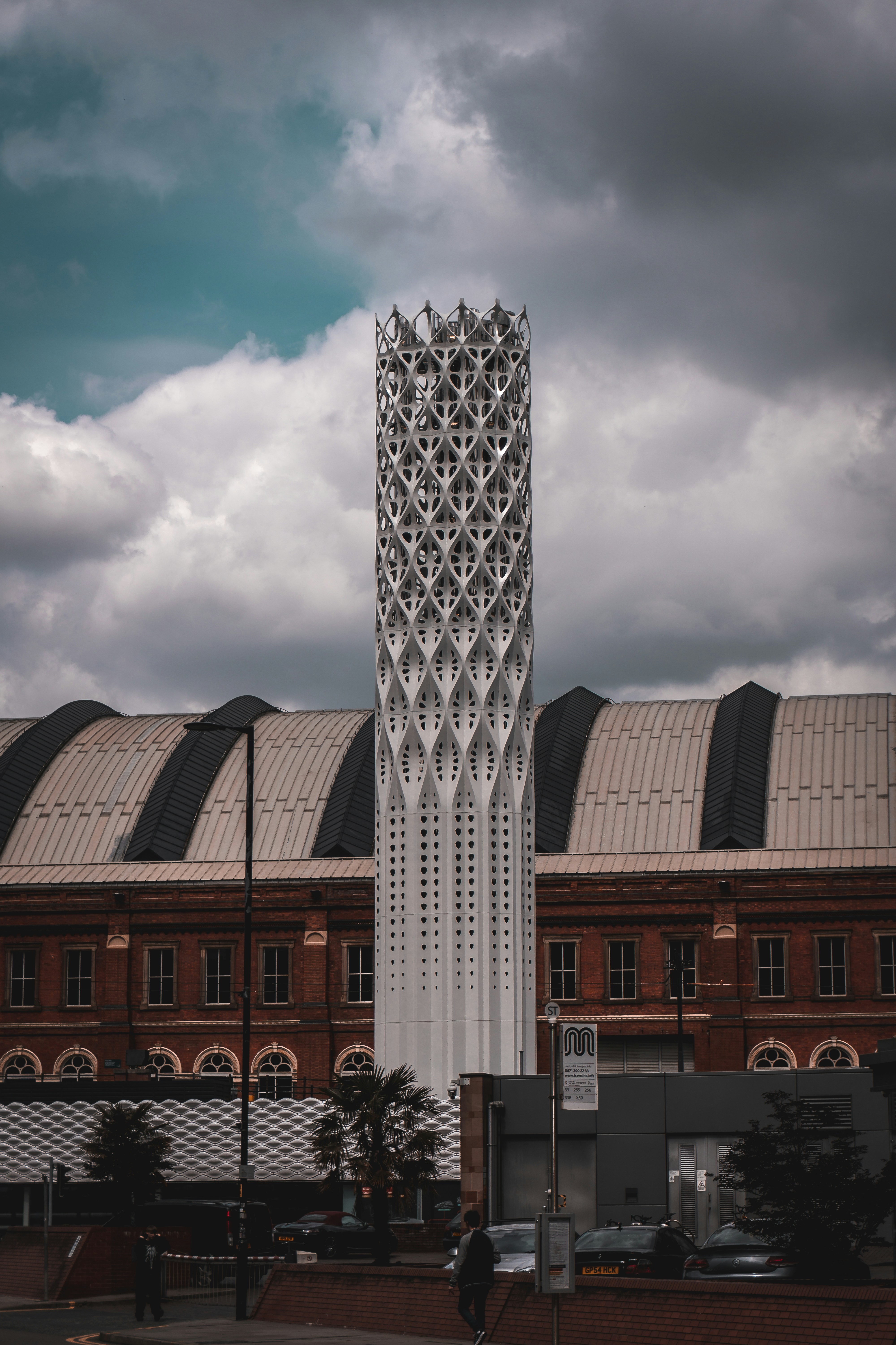 Industrial tower reaches into dramatic sky above curved brick complex