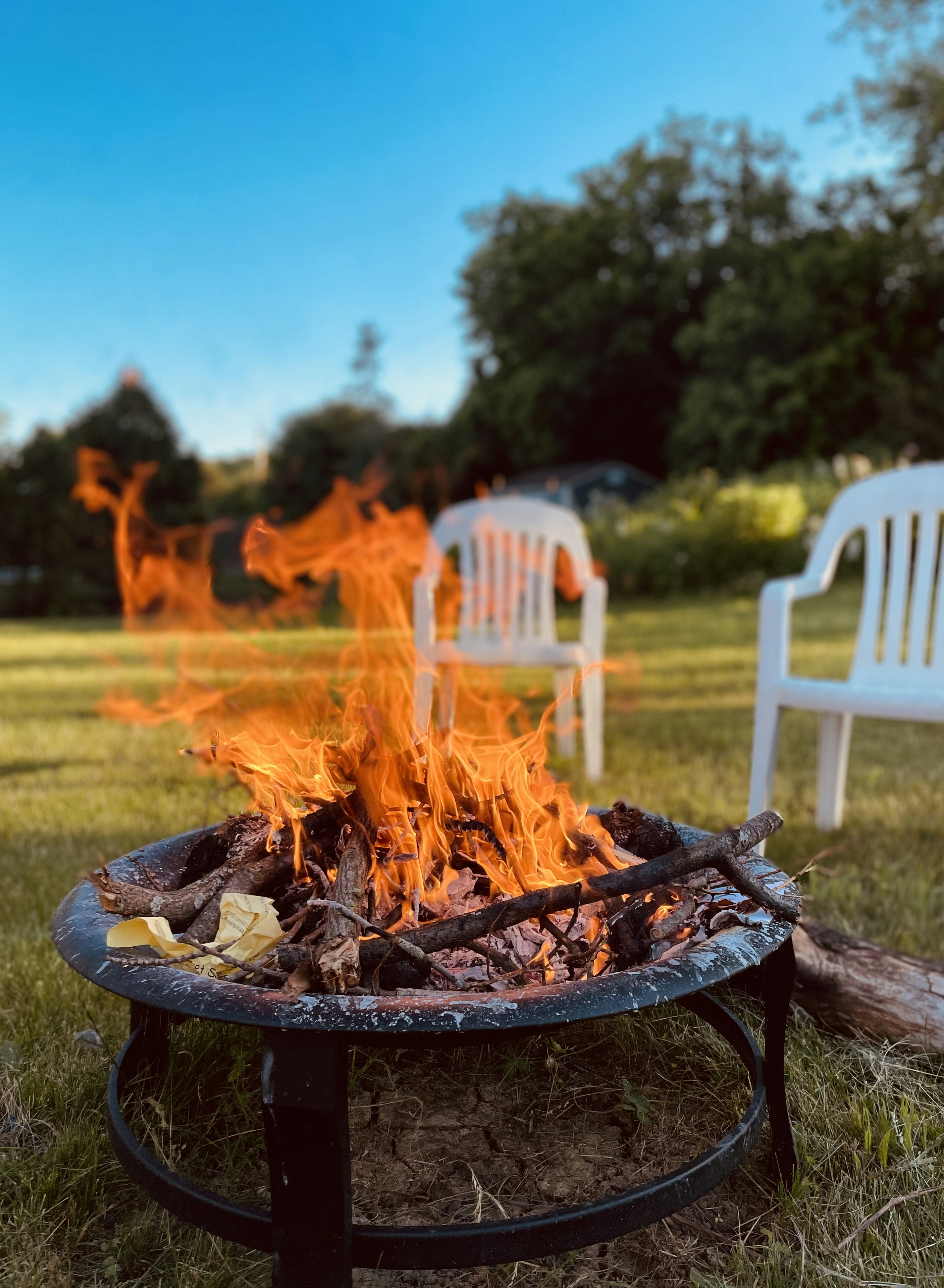 a fire pit with chairs in the background