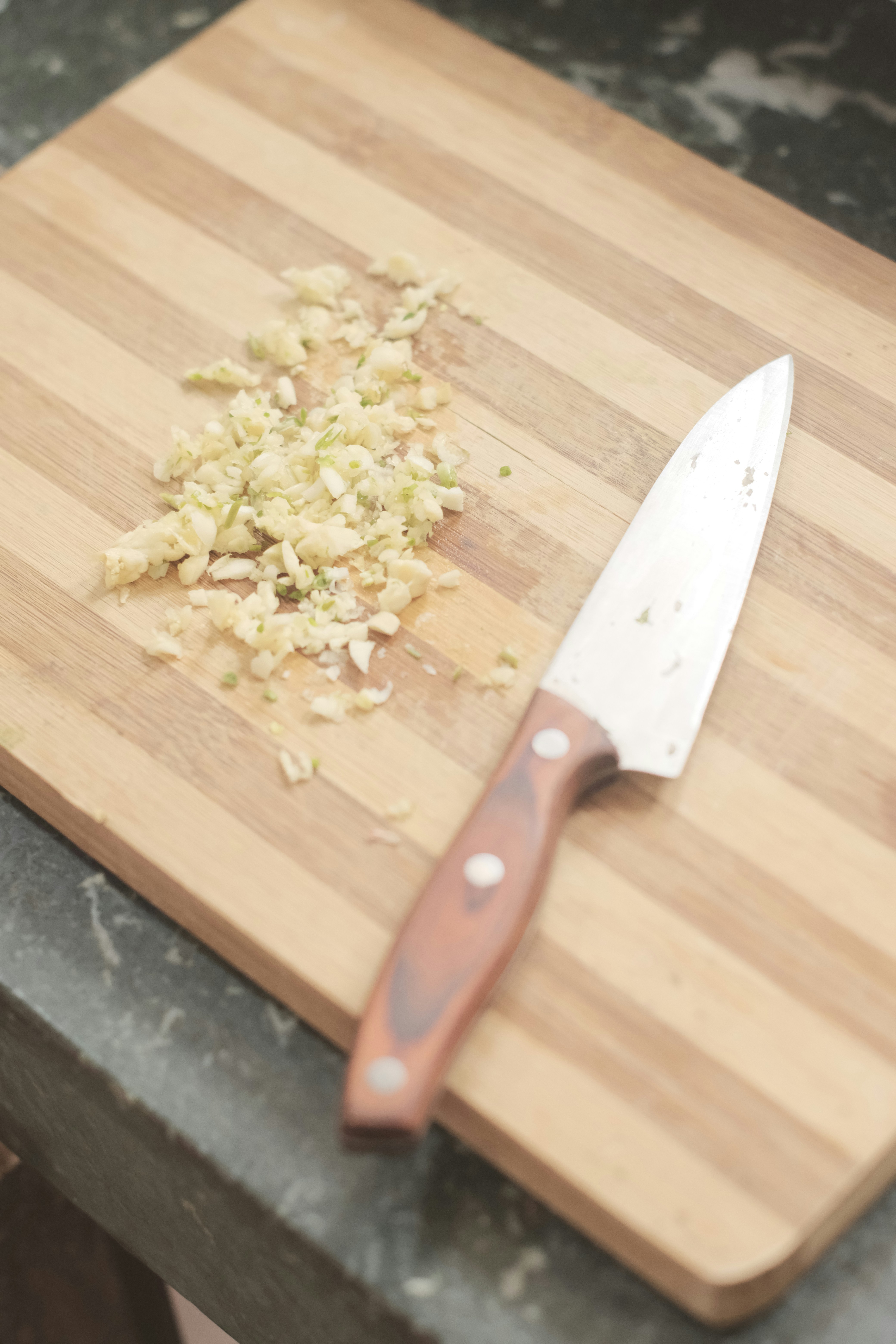 A cutting board with a knife and chopped food on it photo – Free Food ...