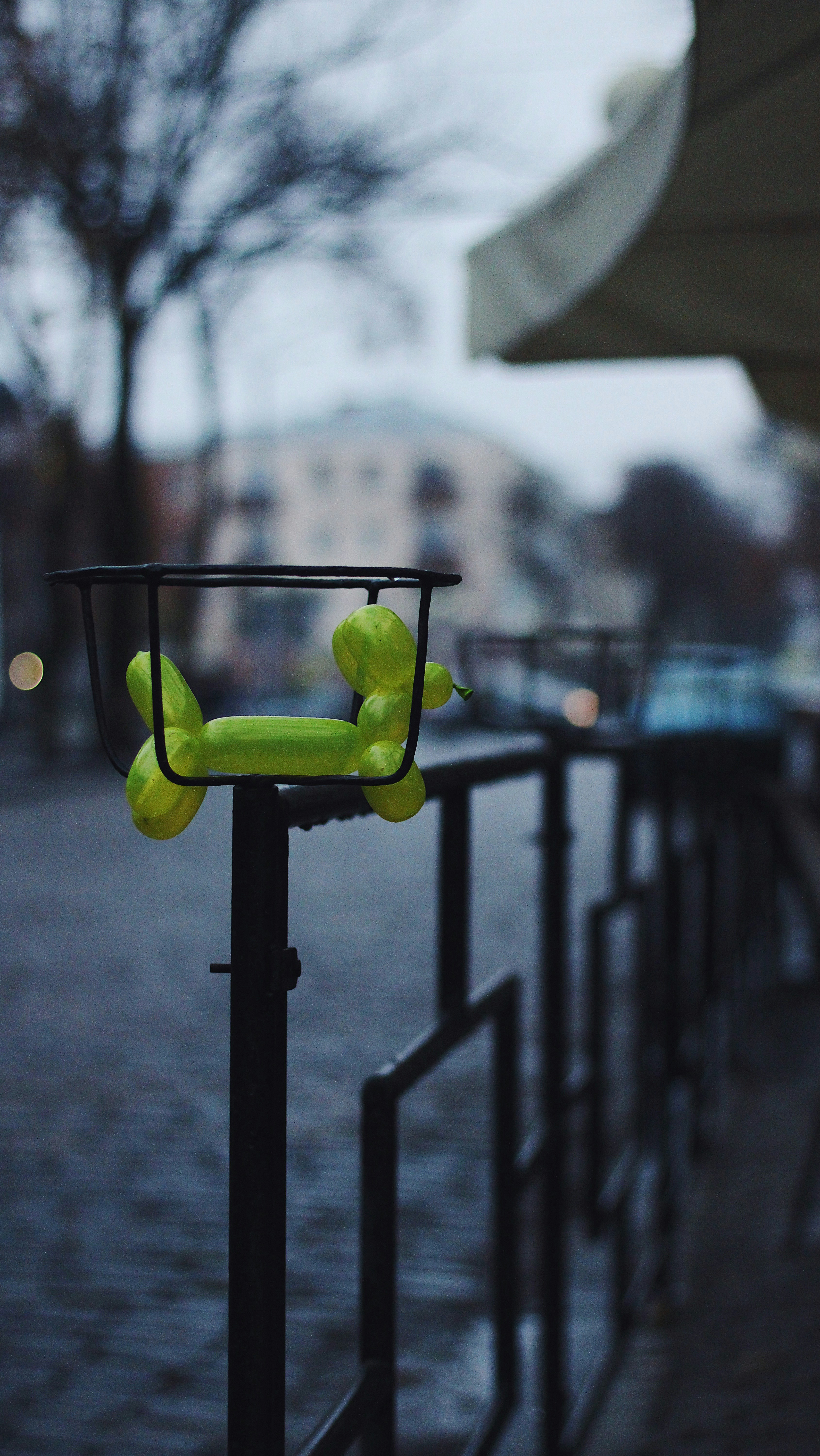 Neon-green Balloon Clip on a Rail: Focused Amid Urban Quiet