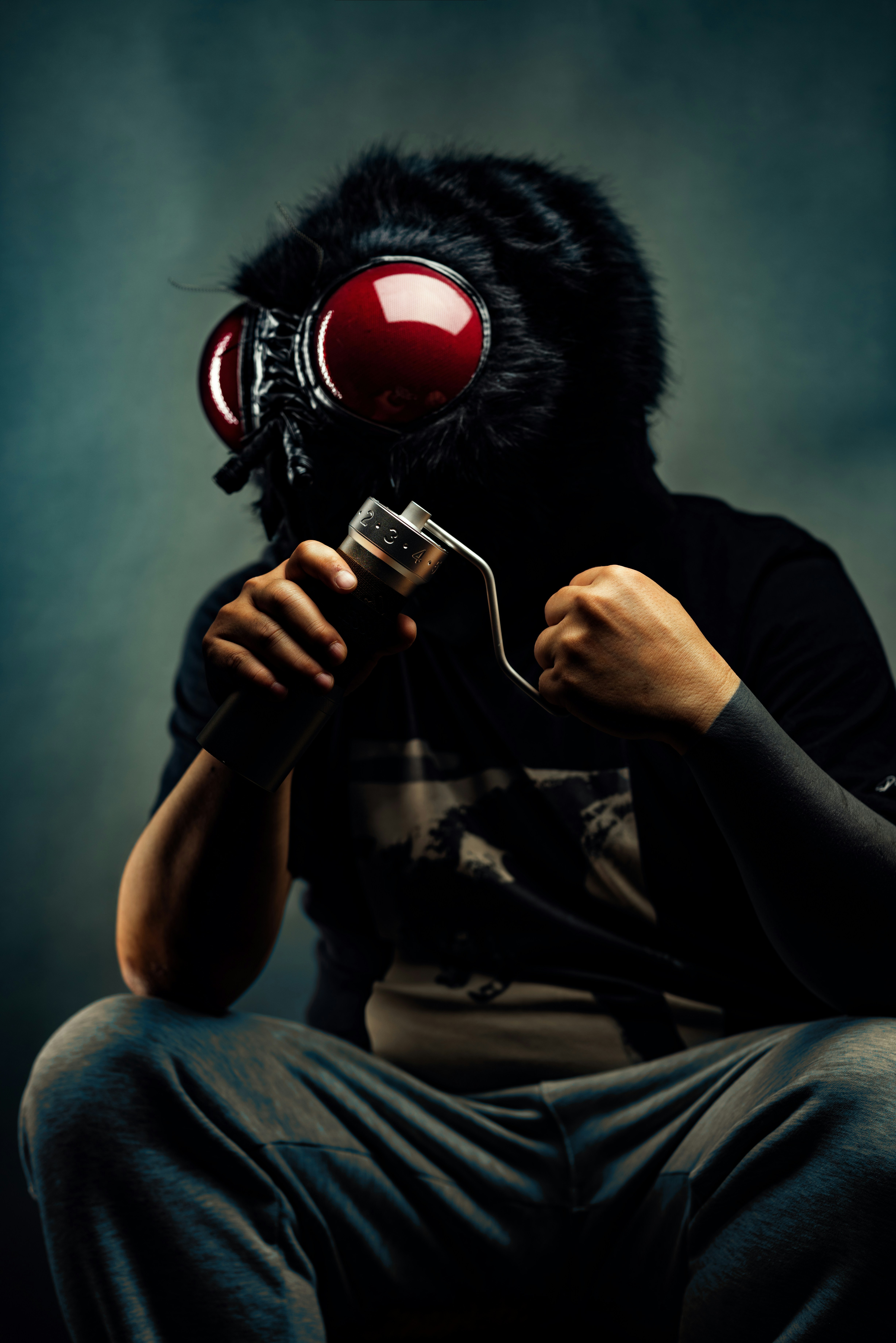 Crimson Echoes: A masked figure with oversized red headphones grips a chrome tool in moody studio light