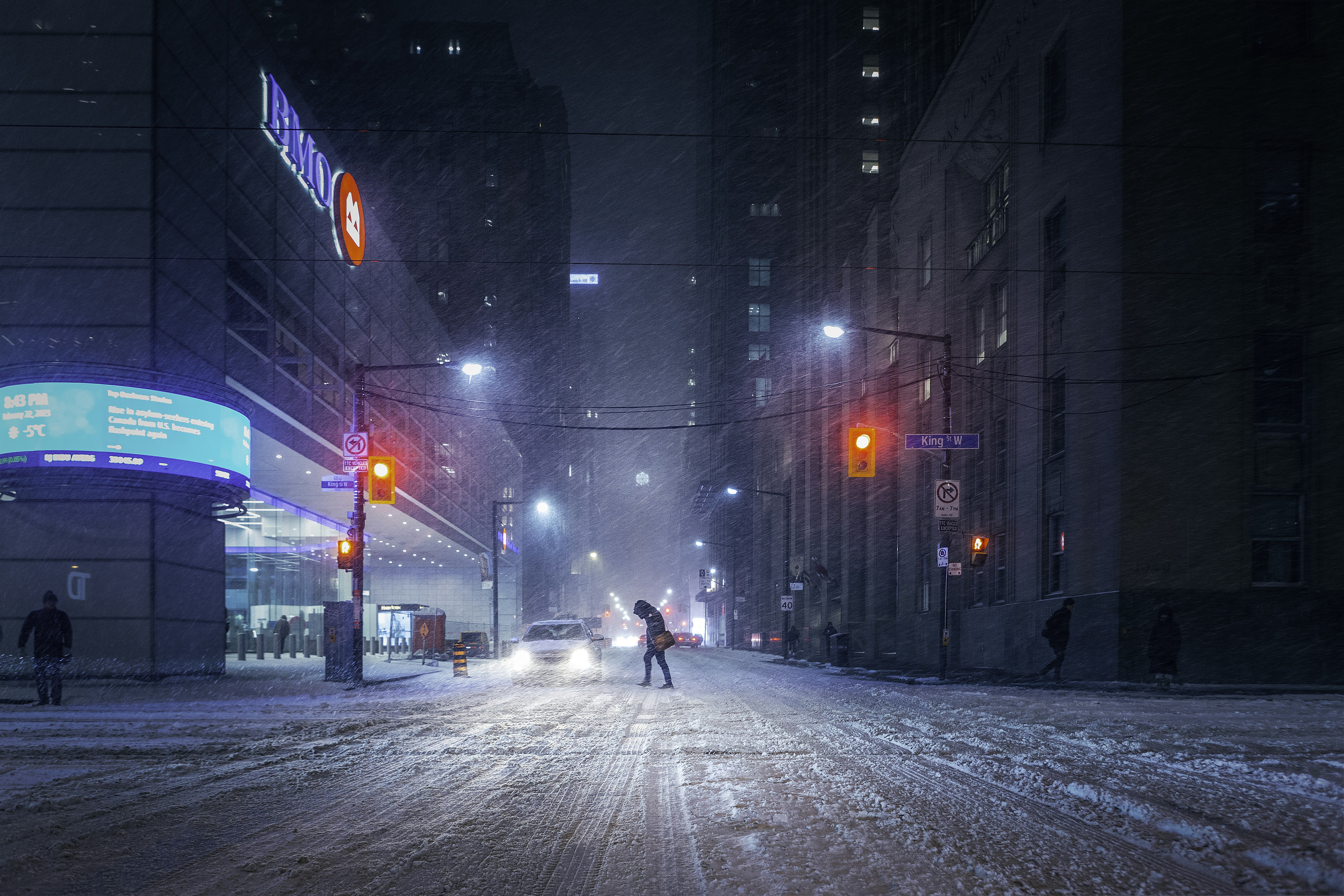 A couple of people walking across a snow covered street photo – Free ...