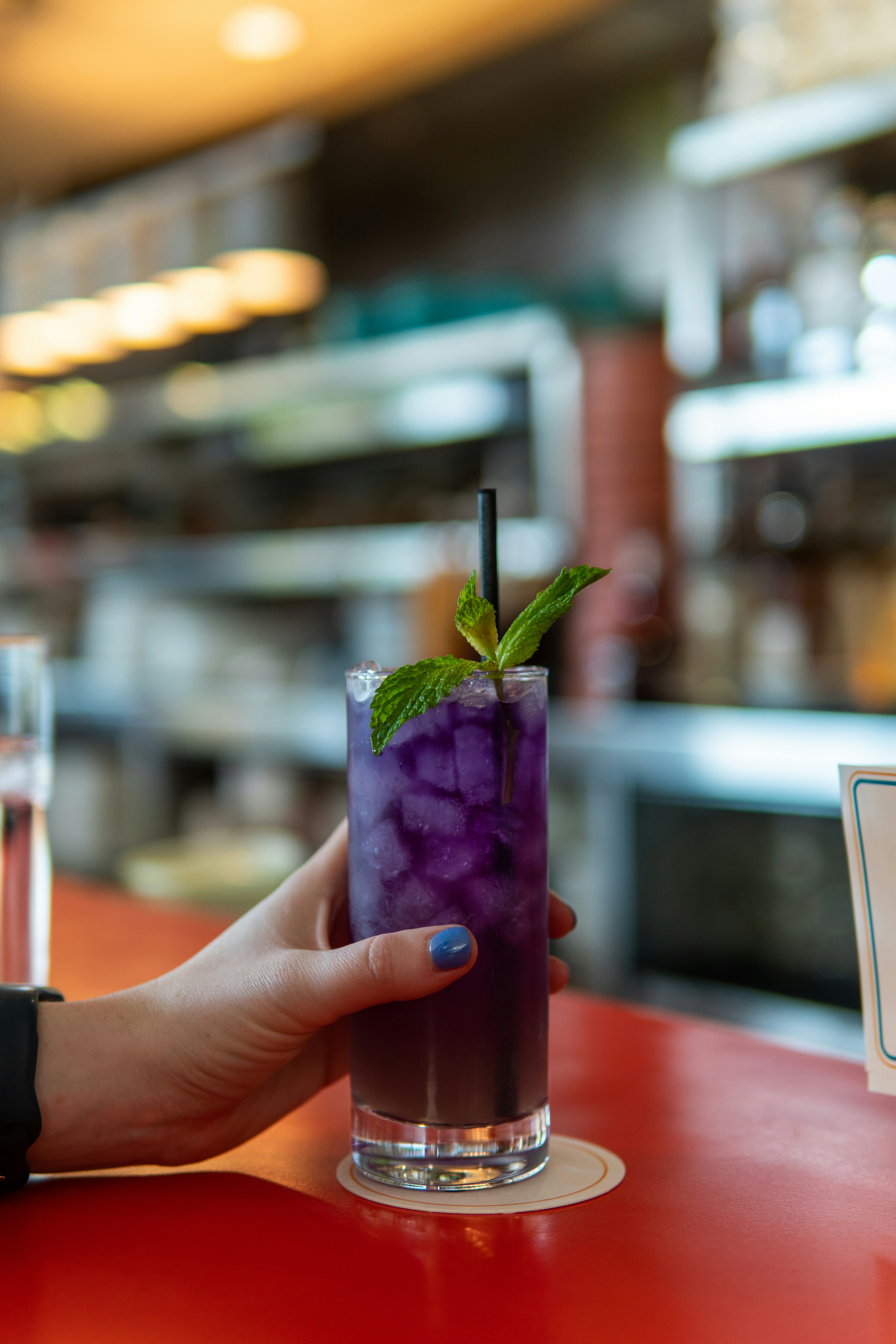 A hand holding a purple drink with a green leaf photo – Free Mint Image ...
