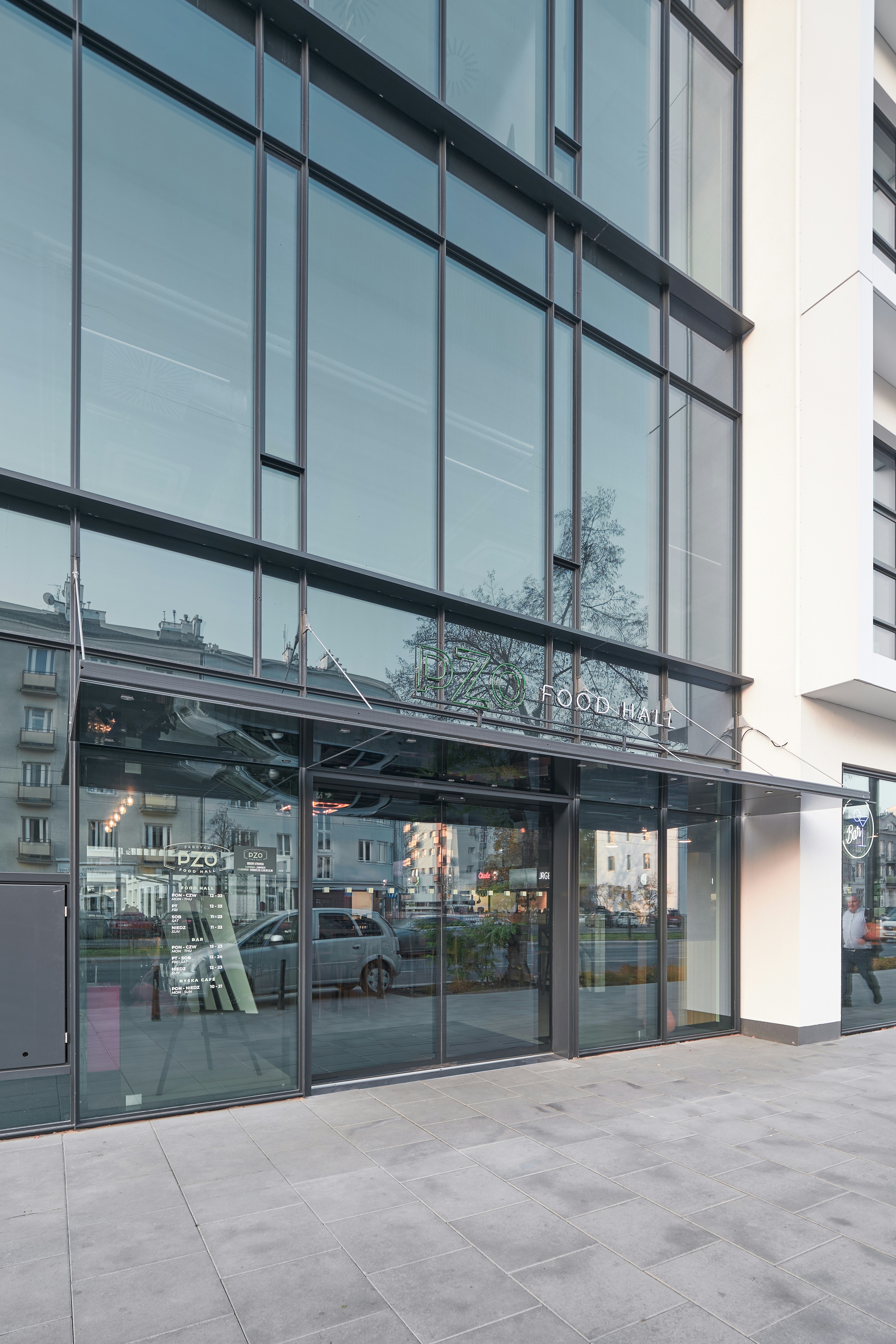 A large glass building with a parking lot in front of it photo – Free ...
