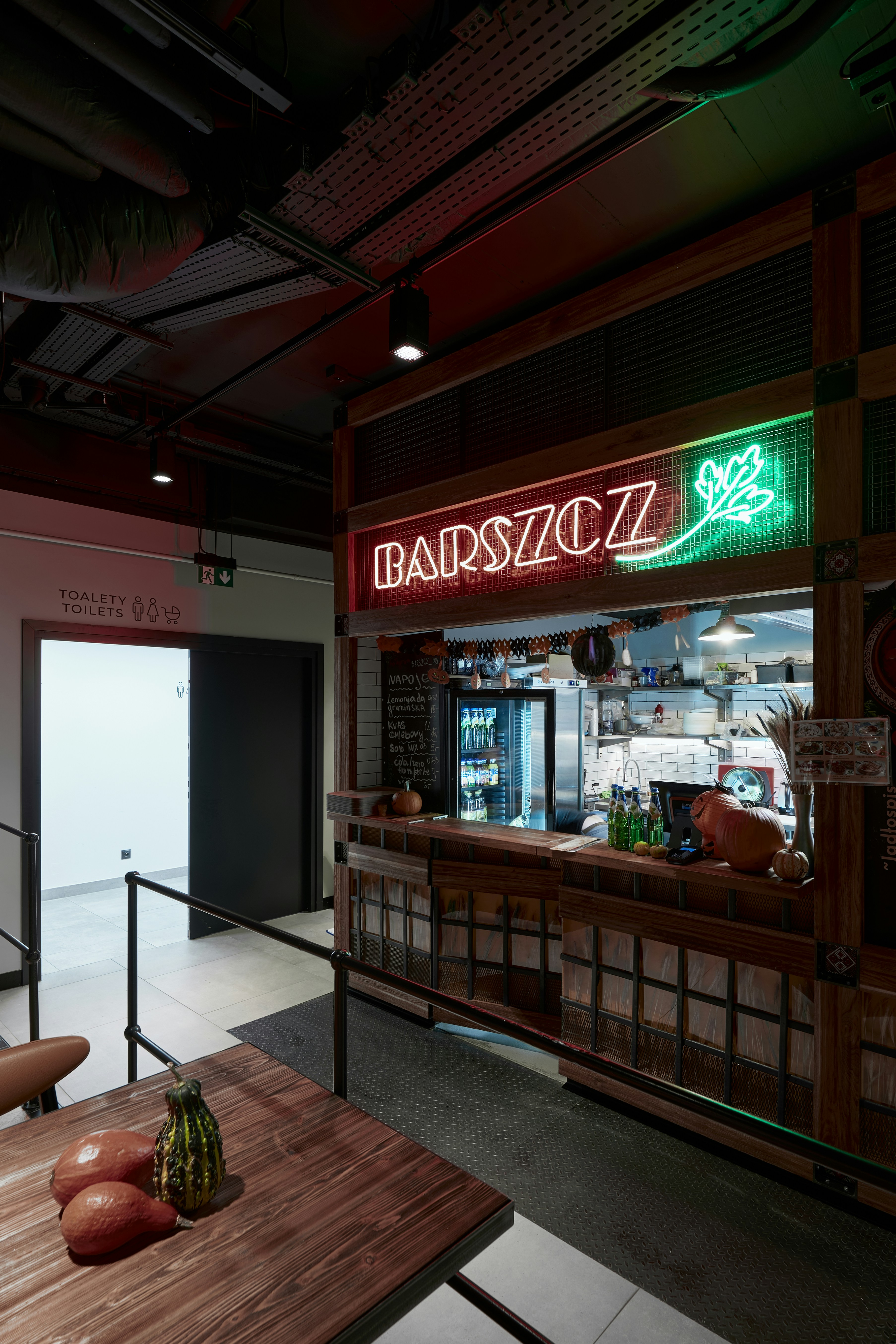 A restaurant with a wooden table and a neon sign photo – Free Warsaw ...
