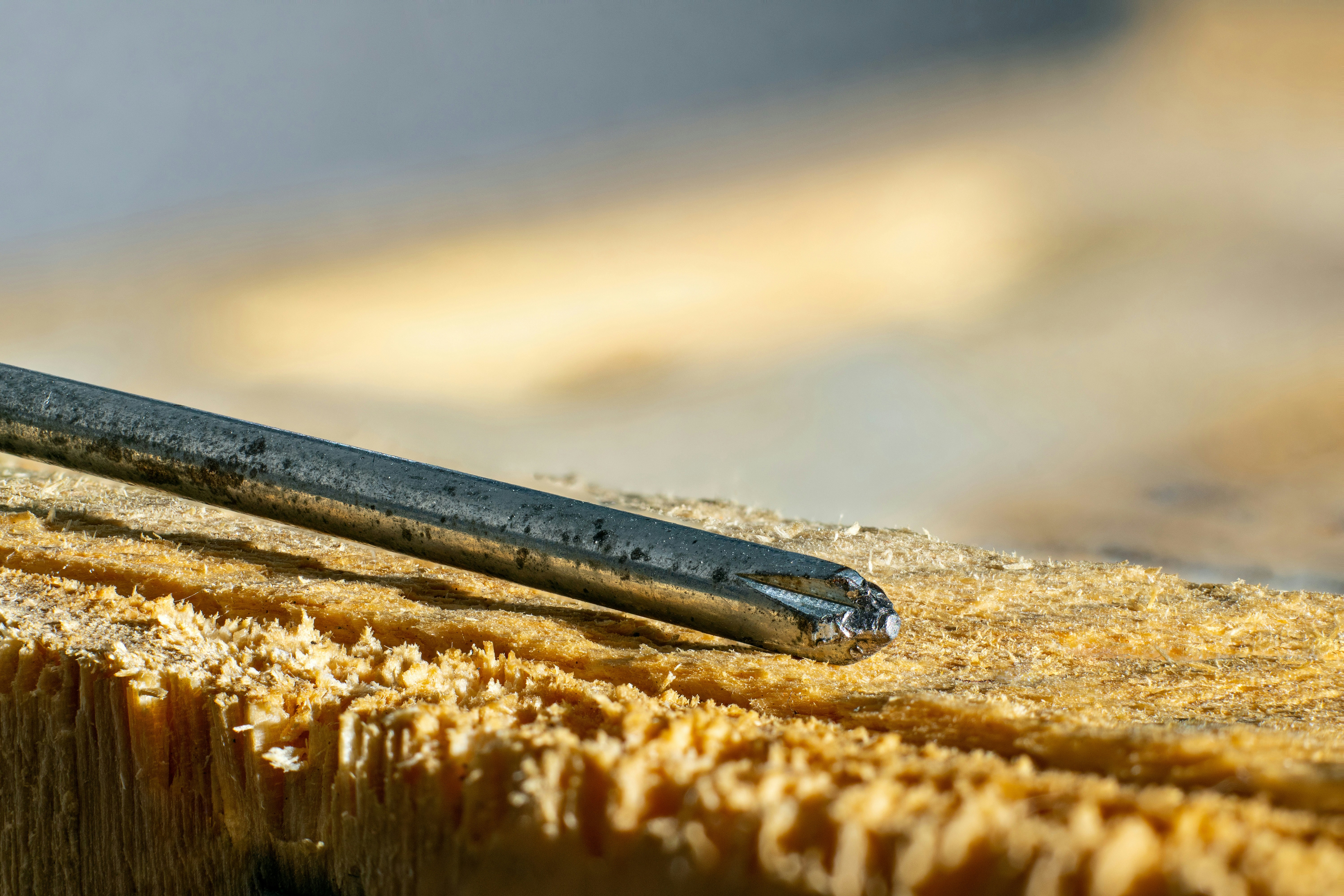 Closeup macro shot of the tip of a screwdriver on top of a wooden plank