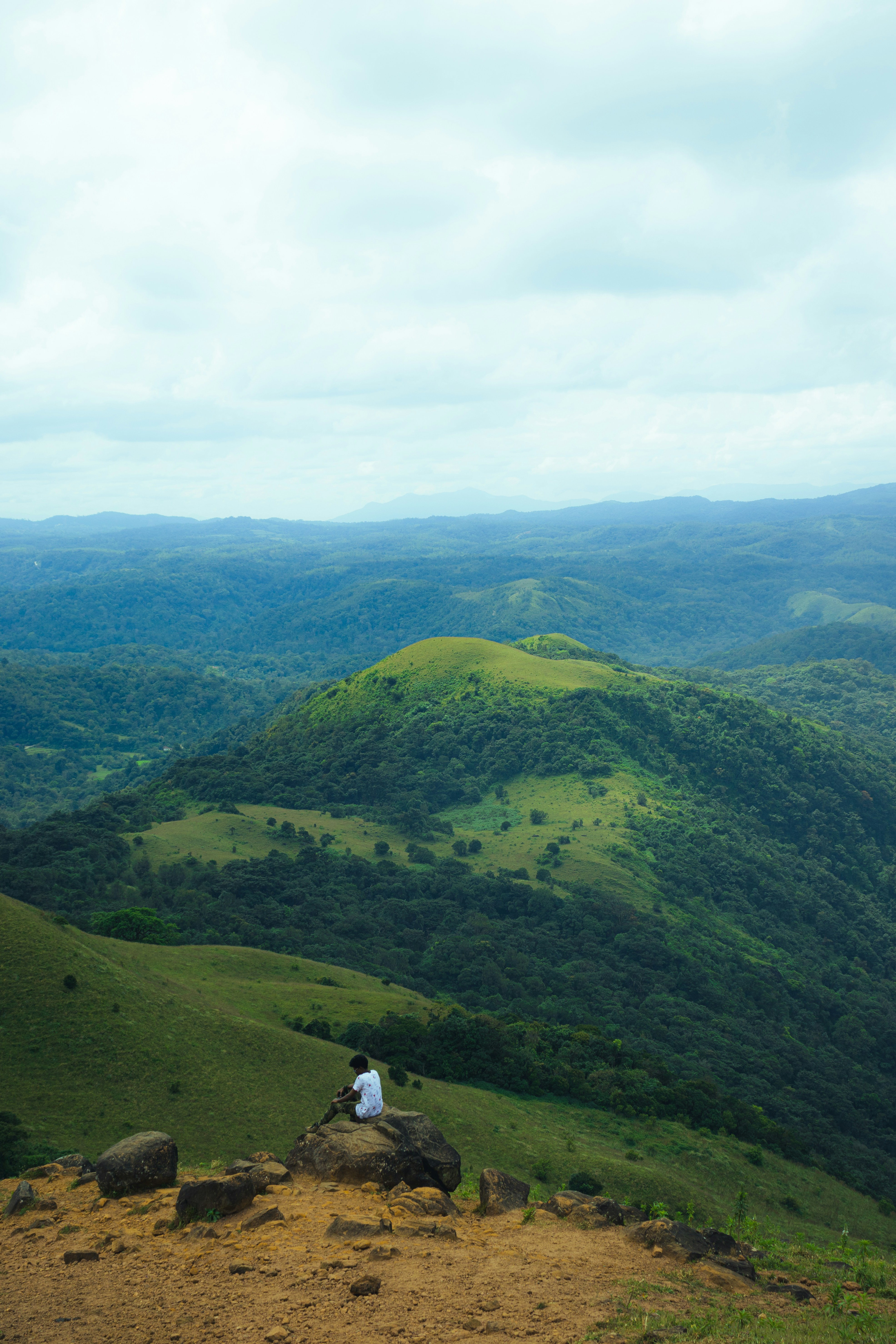 Foto Una persona sentada en la cima de una colina con vistas a un valle ...