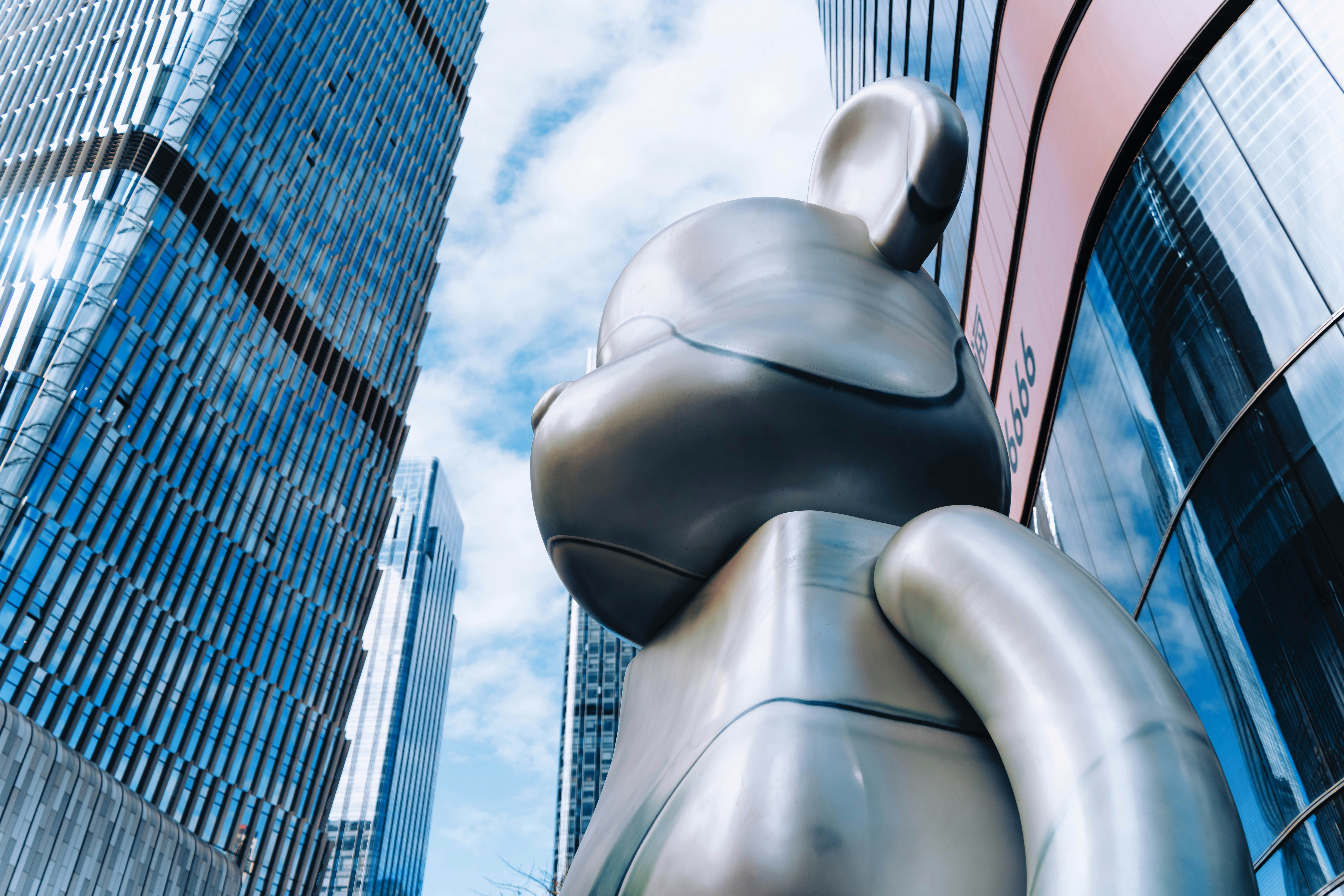 A large metal statue in front of a tall building photo – Free City ...