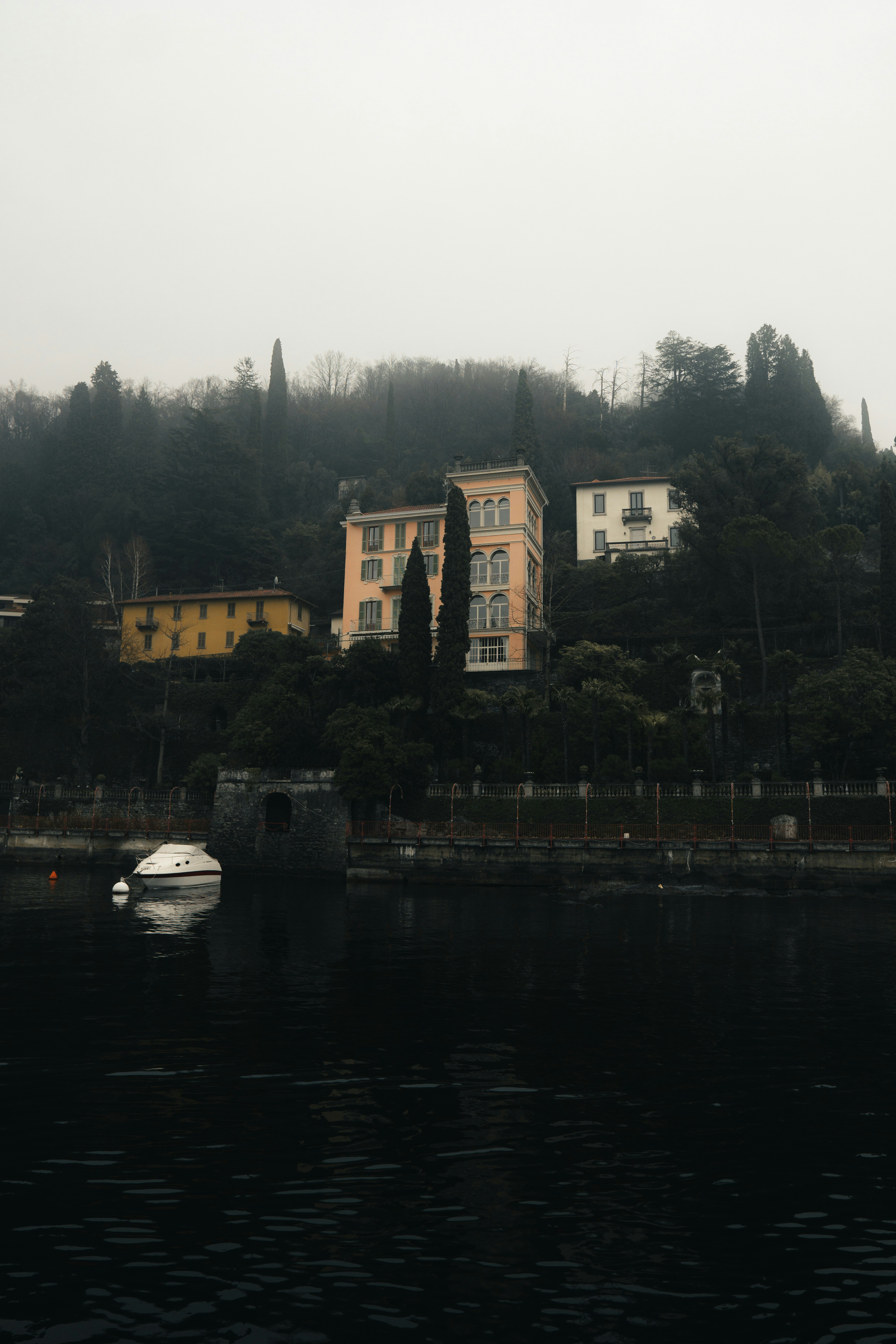 a house on a hill with a boat in the water