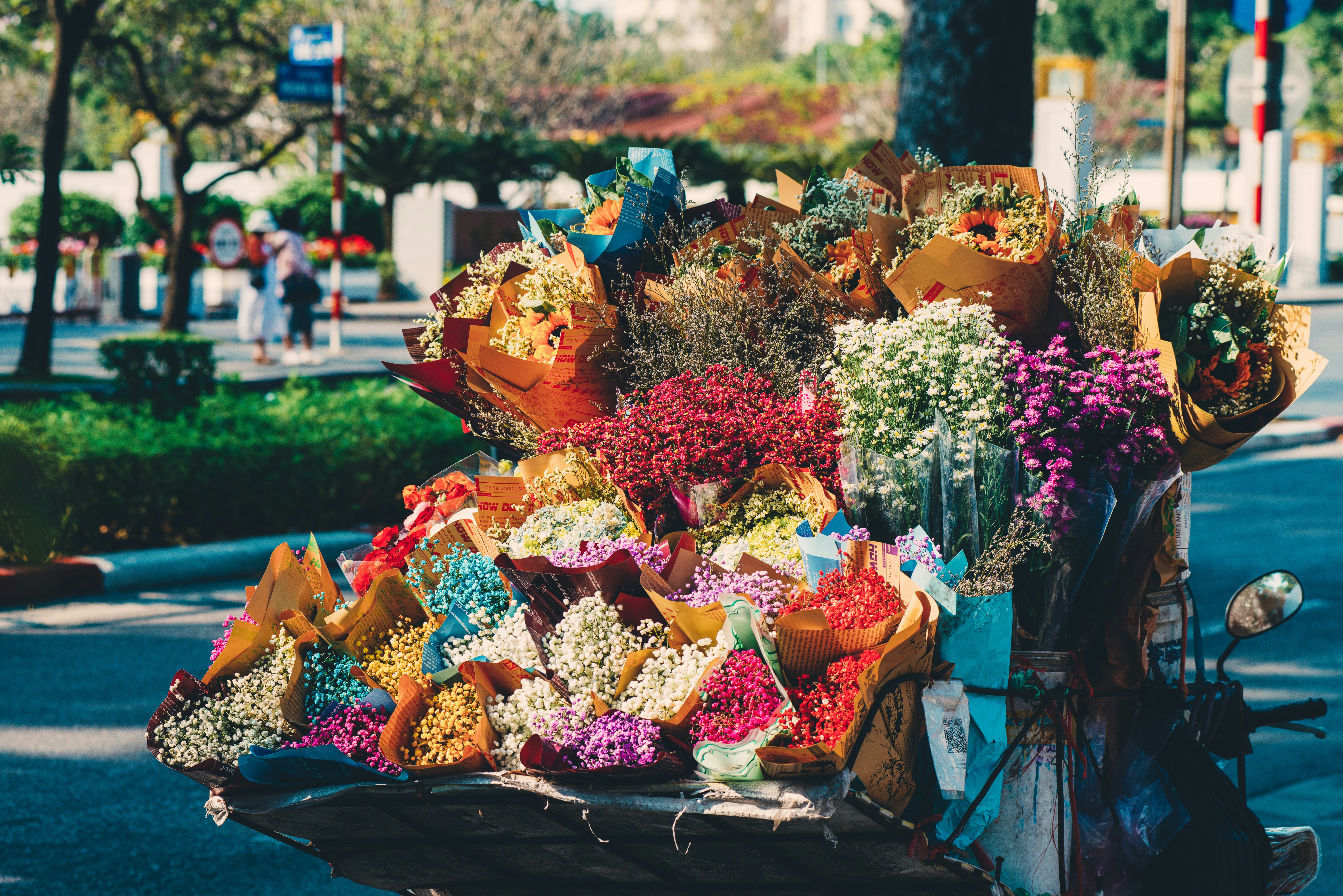 a cart full of flowers on the side of the road