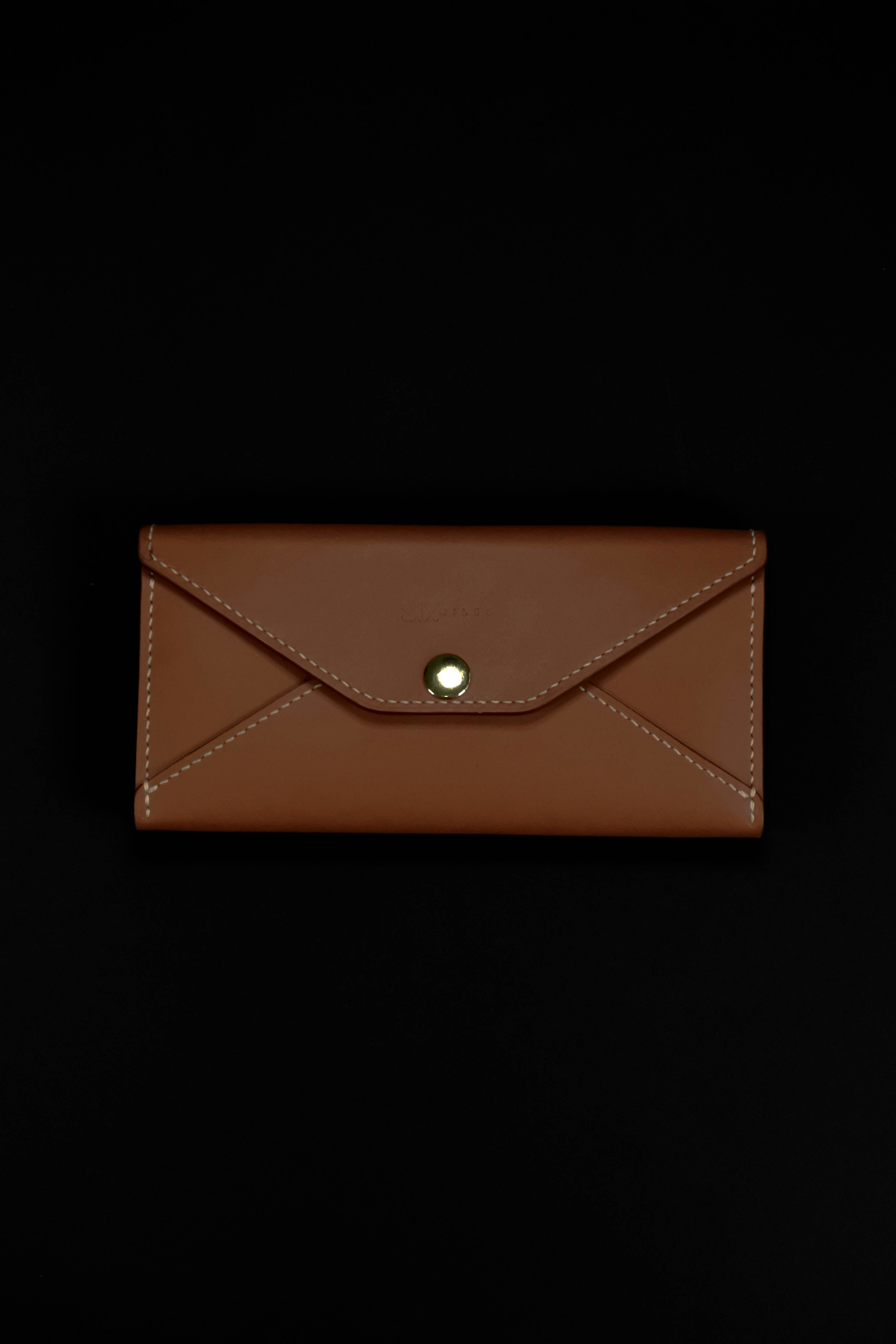 Brown leather wallet with a snap closure displayed against a black background.