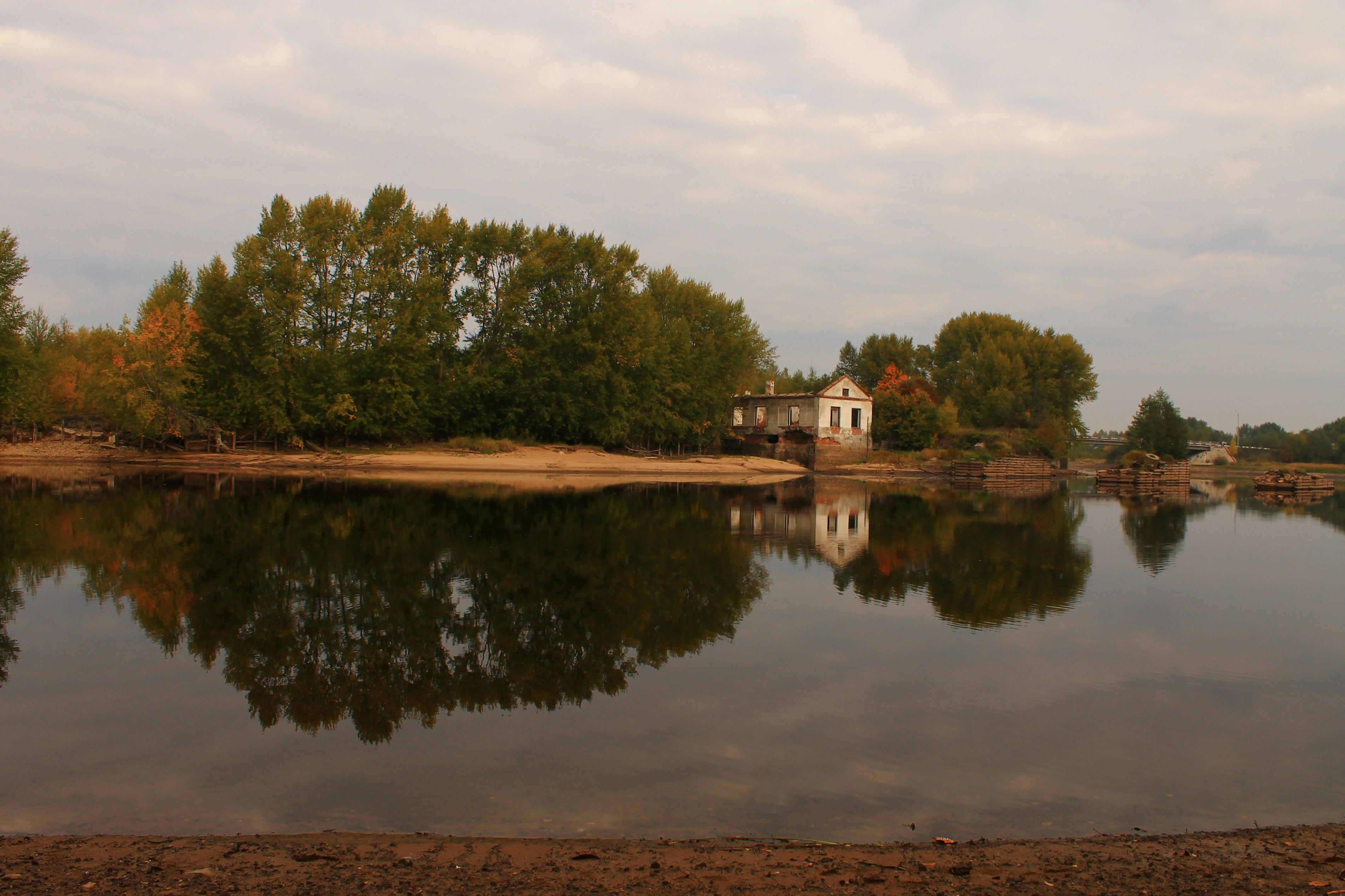 Autumn Quiet on the River: A White House Framed by Trees and Reflections