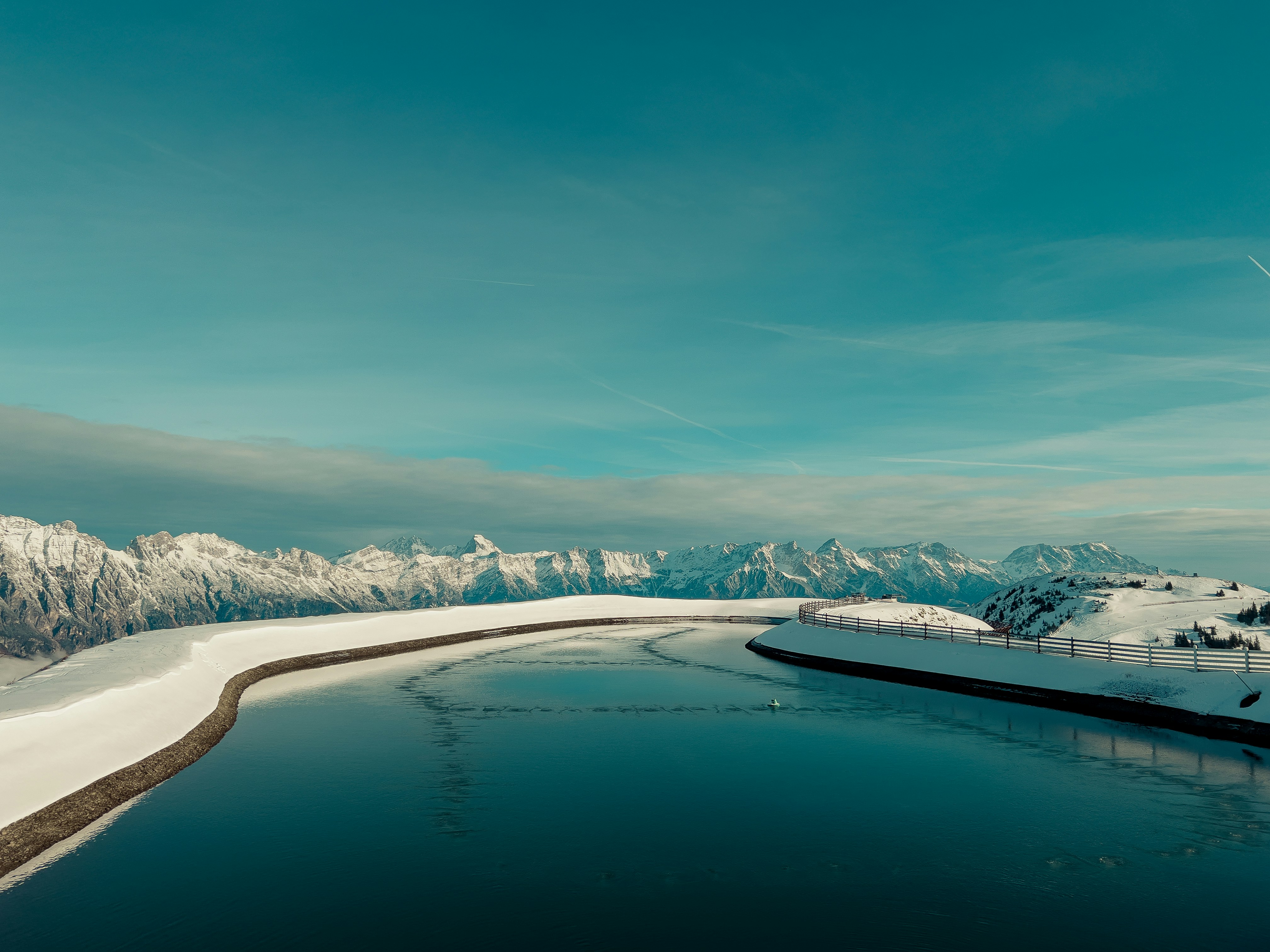a large body of water surrounded by snow covered mountains