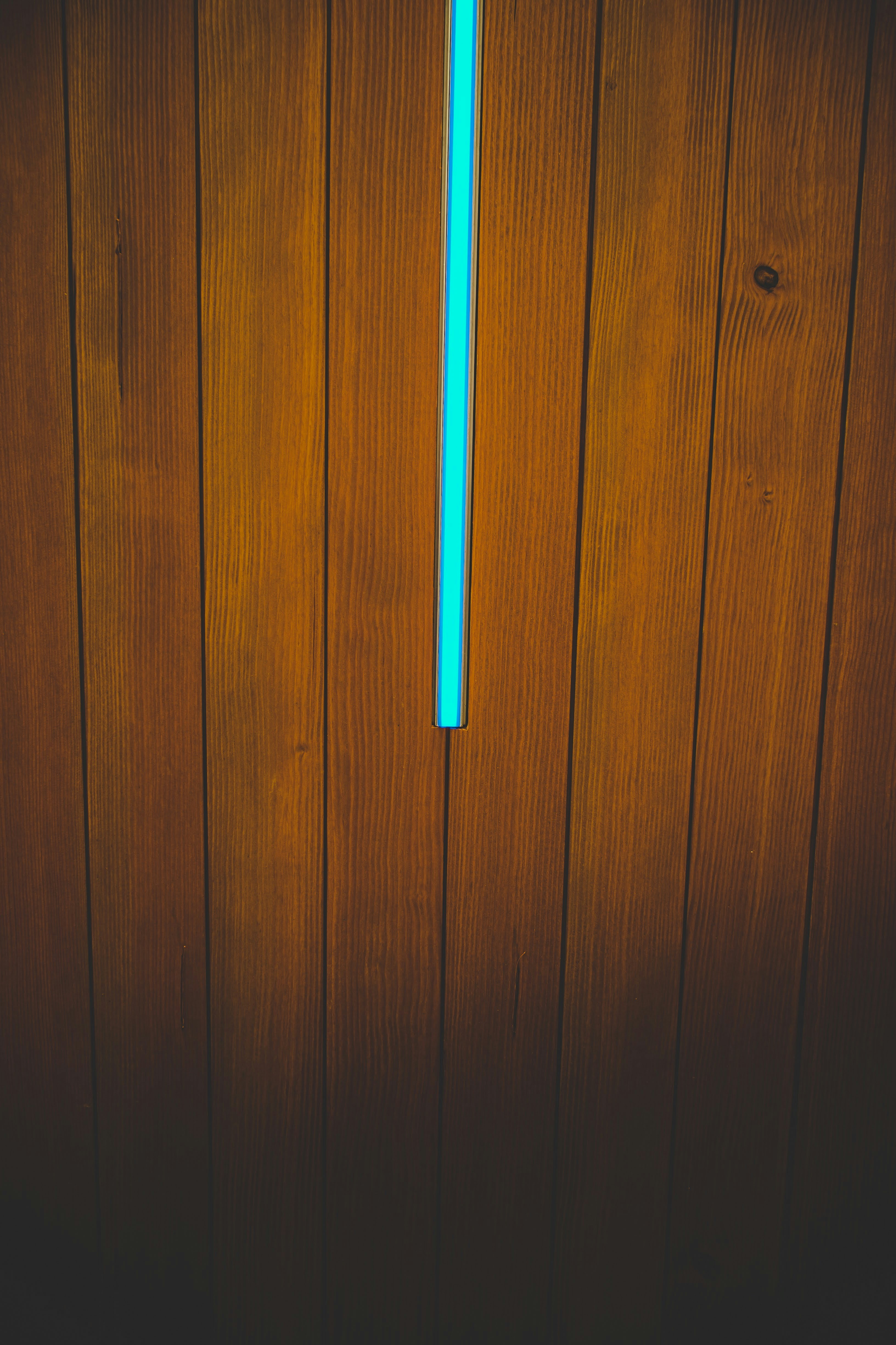 a wooden door with a blue handle on it