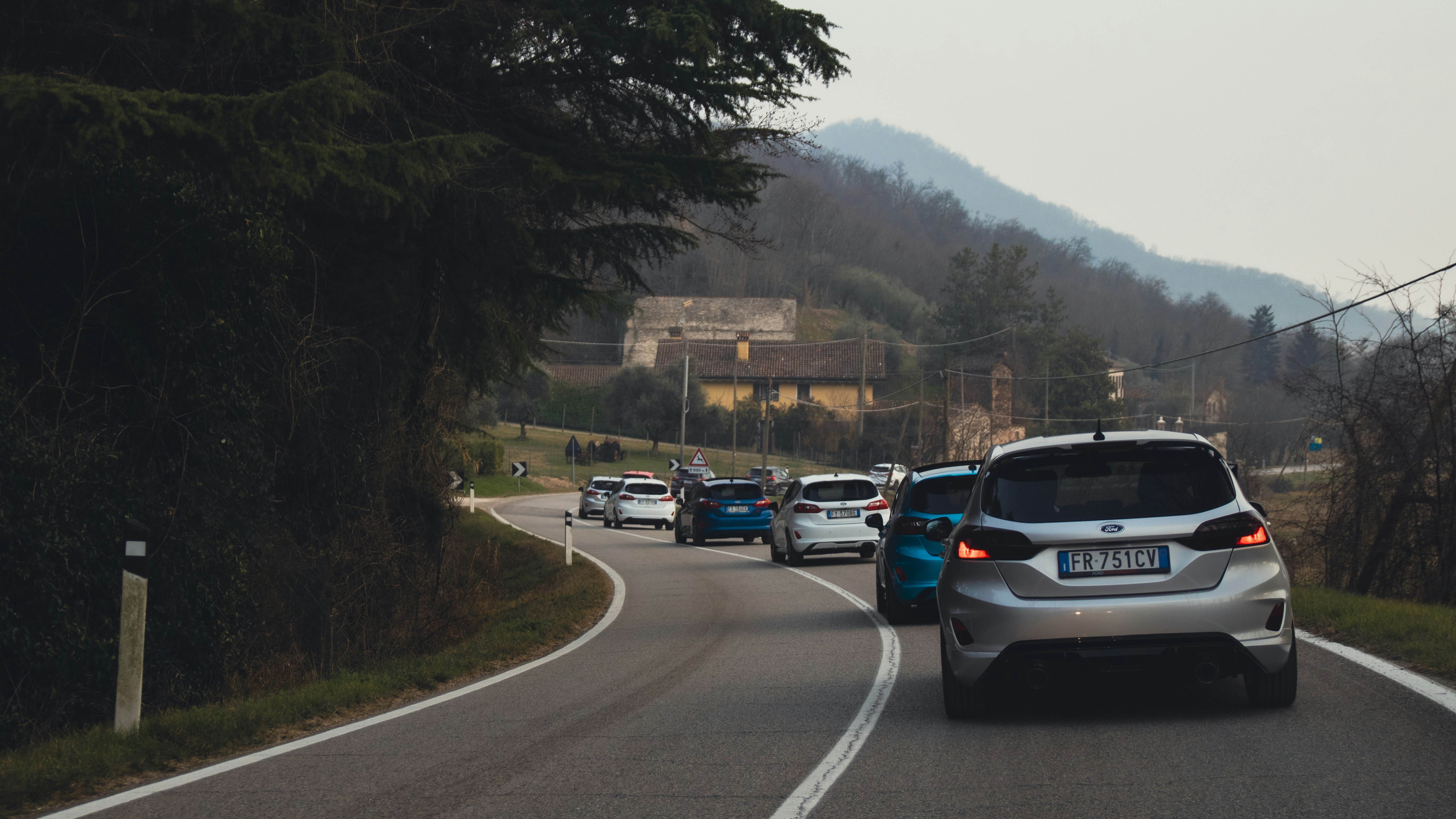 Winding Convoy: Cars Navigate a Curved Rural Highway