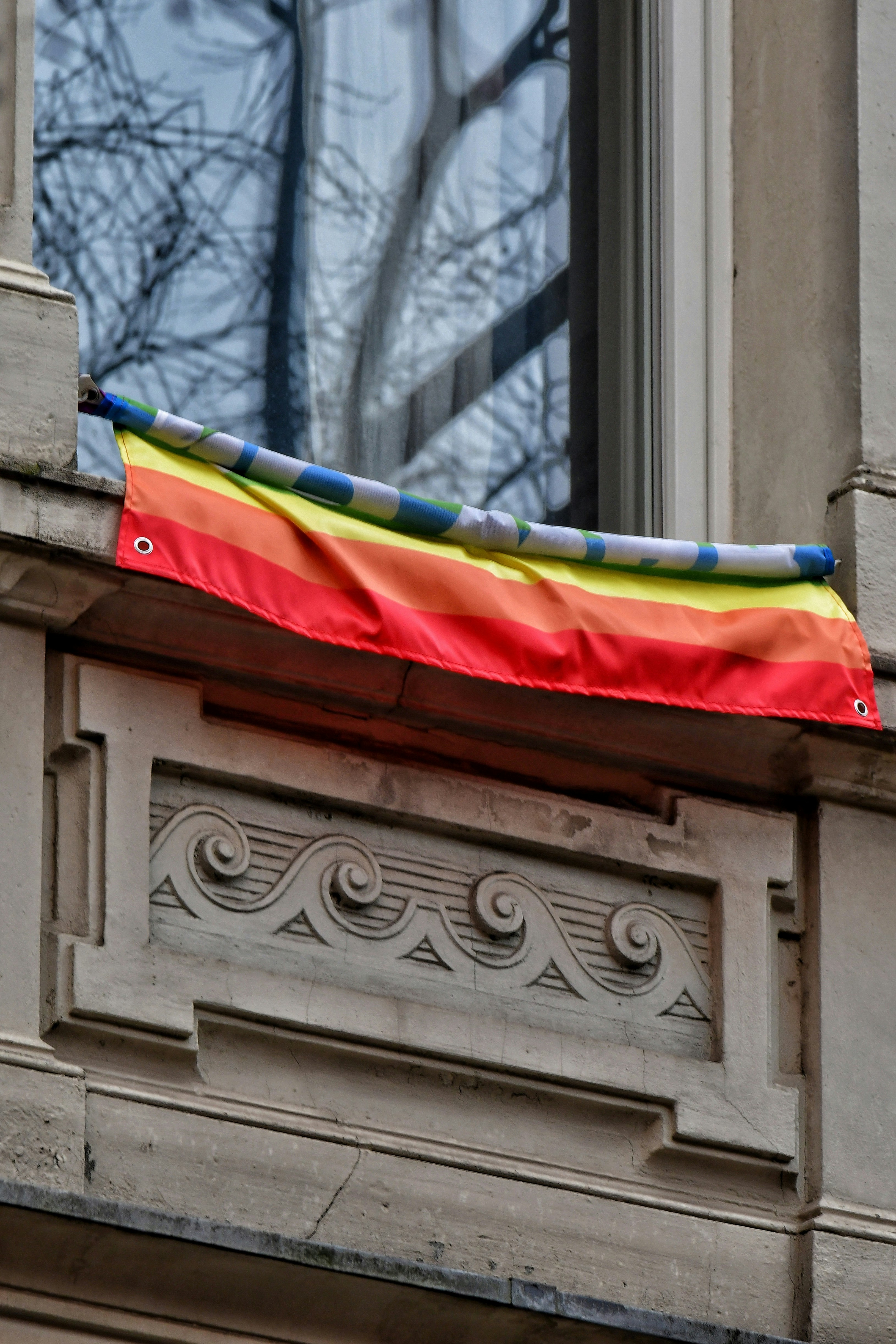 A rainbow flag hanging from a window sill photo – Free Flag Image on ...
