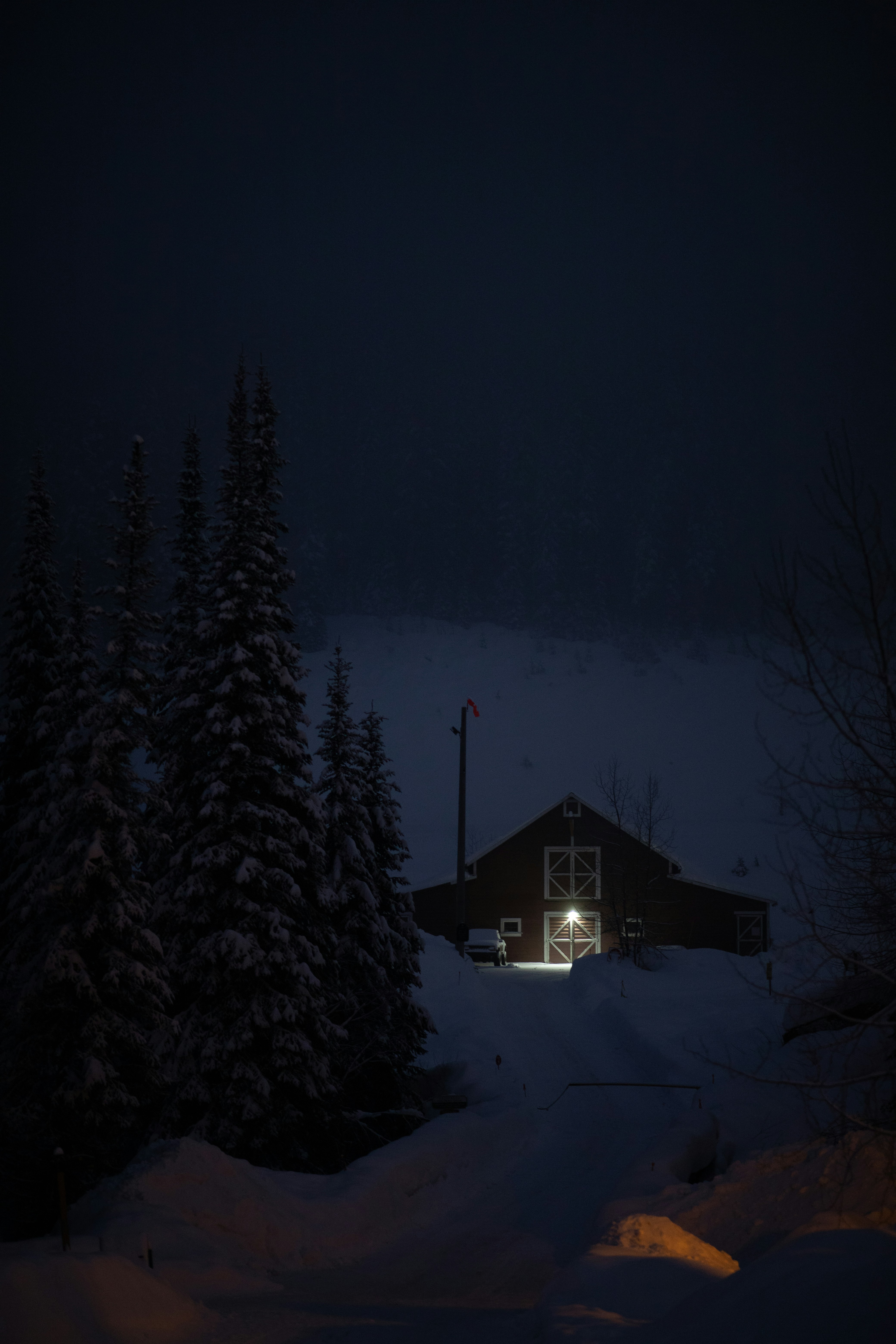 Winter's Lantern: A Snowbound Barn Emerges from Night