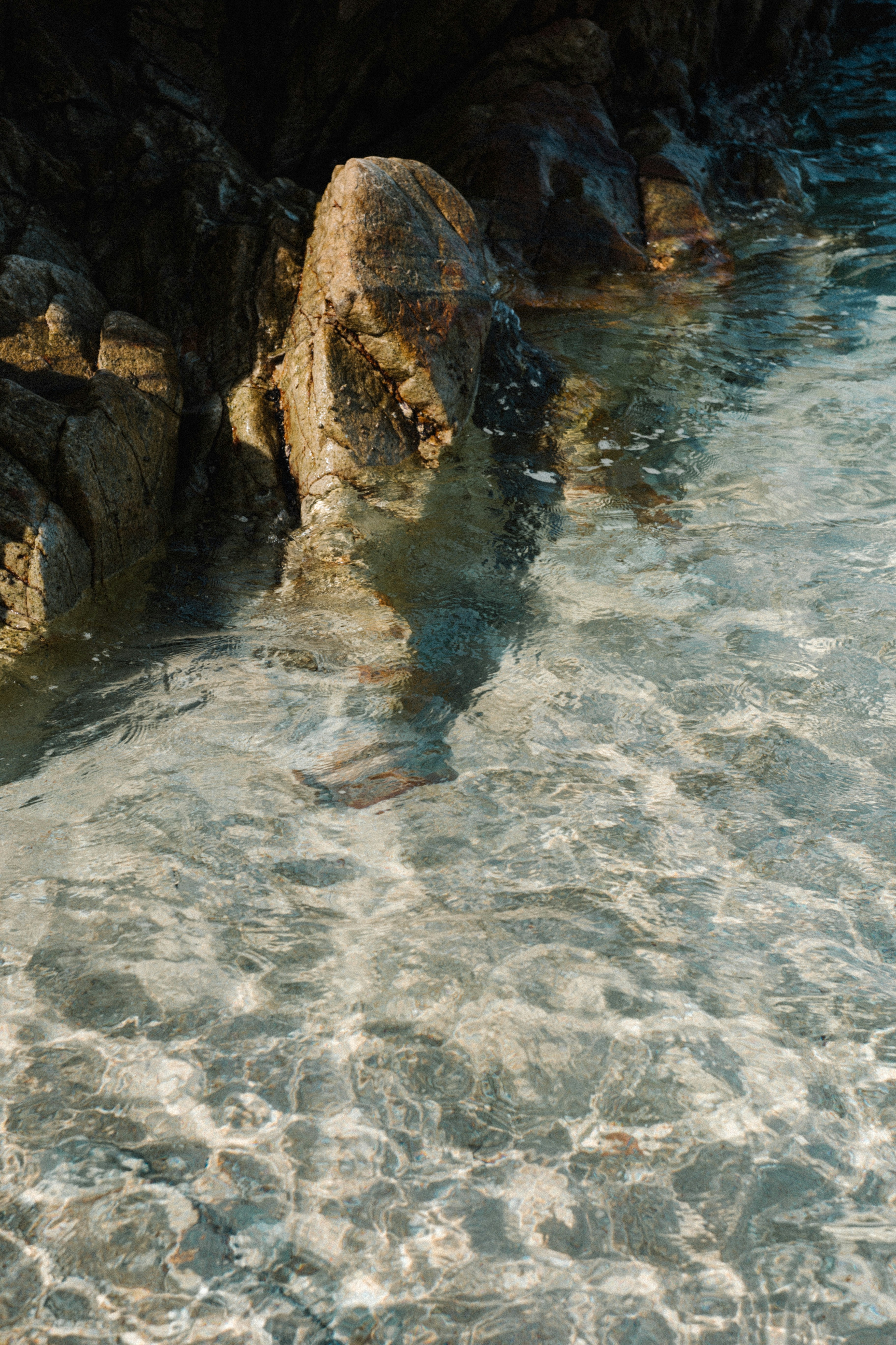 Sun-warmed rock sentinel guarding turquoise tidal pools