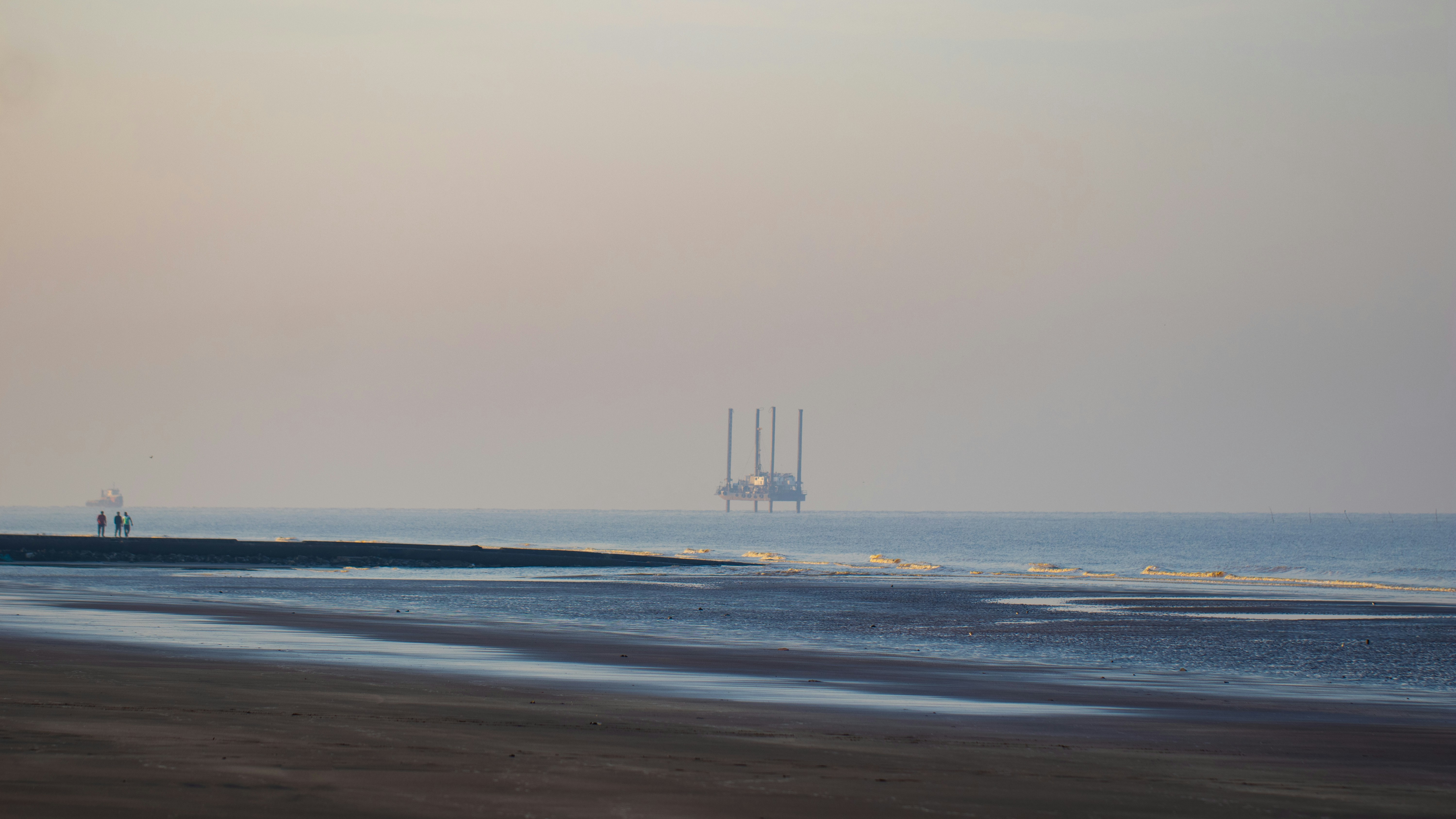 Mist-Hazed Horizon: Distant Offshore Platform from a Quiet Beach