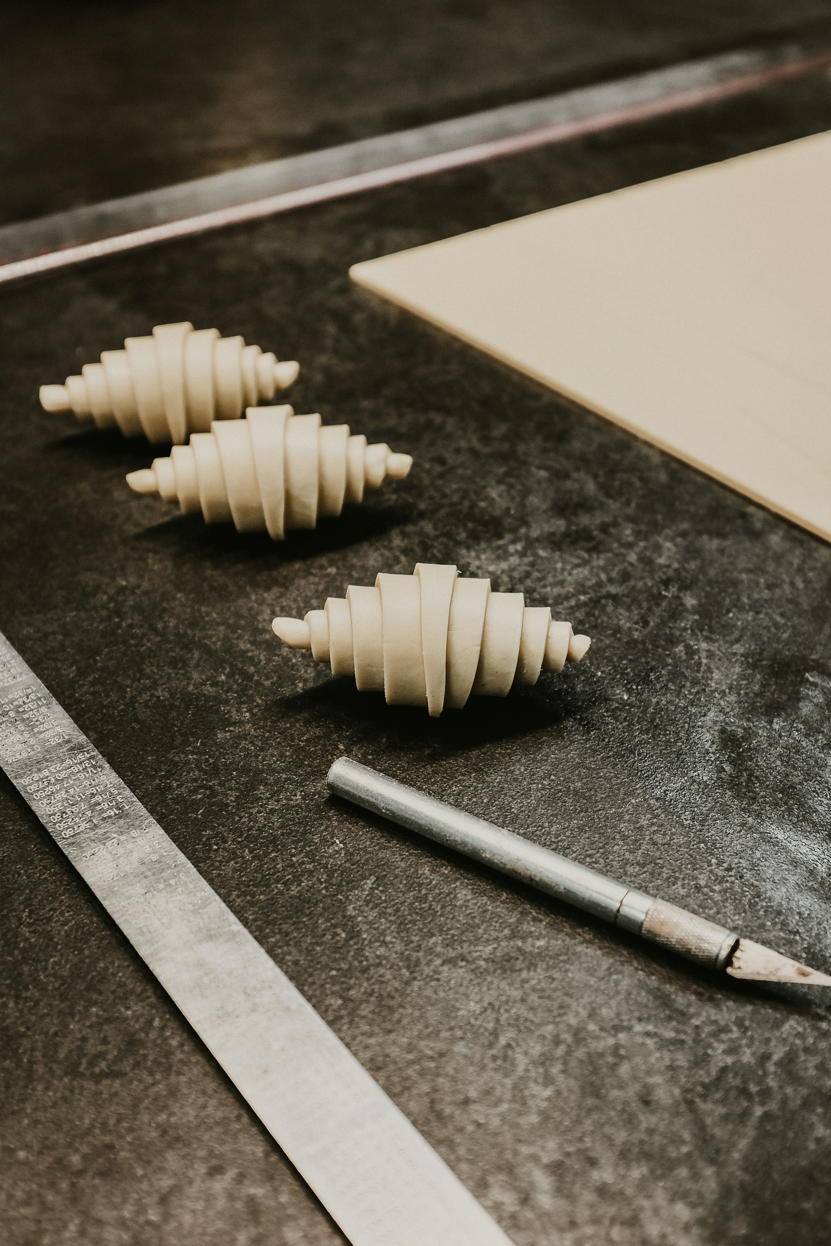 Precision in Wood: Three Spiral Shells on a Steel Worktable
