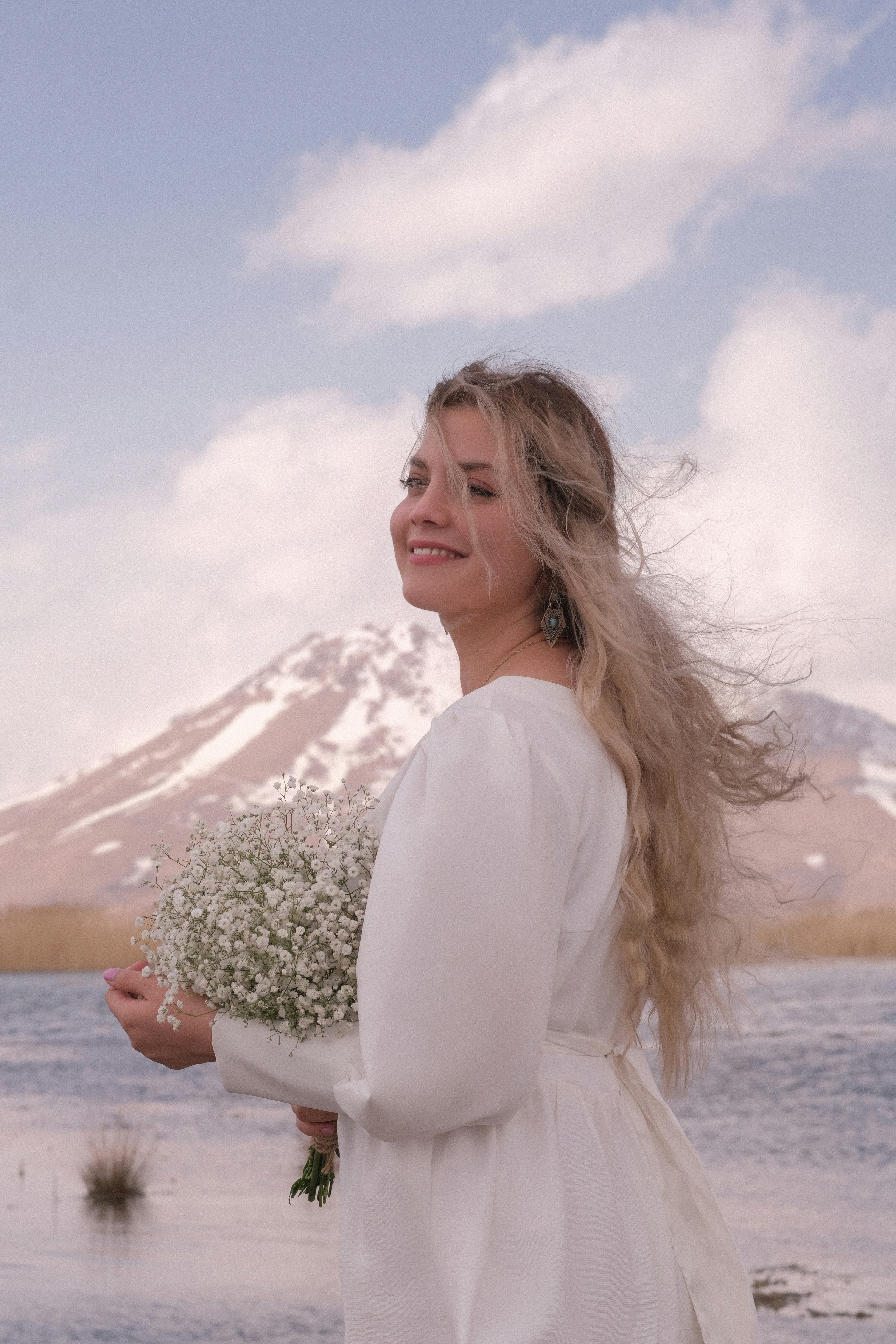 a woman in a white dress holding a bouquet of flowers