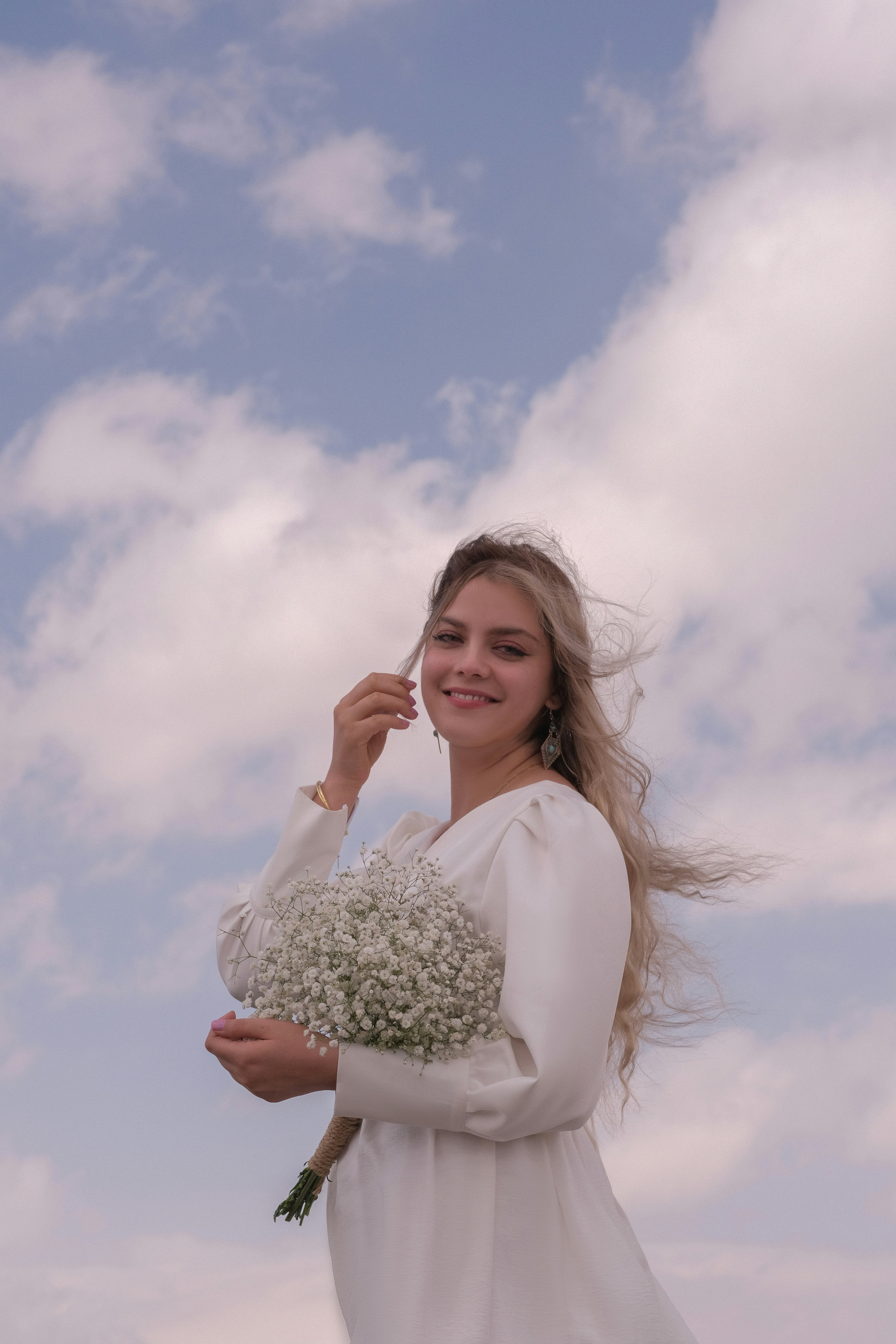 Whispers of White: Bride with Baby's Breath under a Wind-Kissed Sky