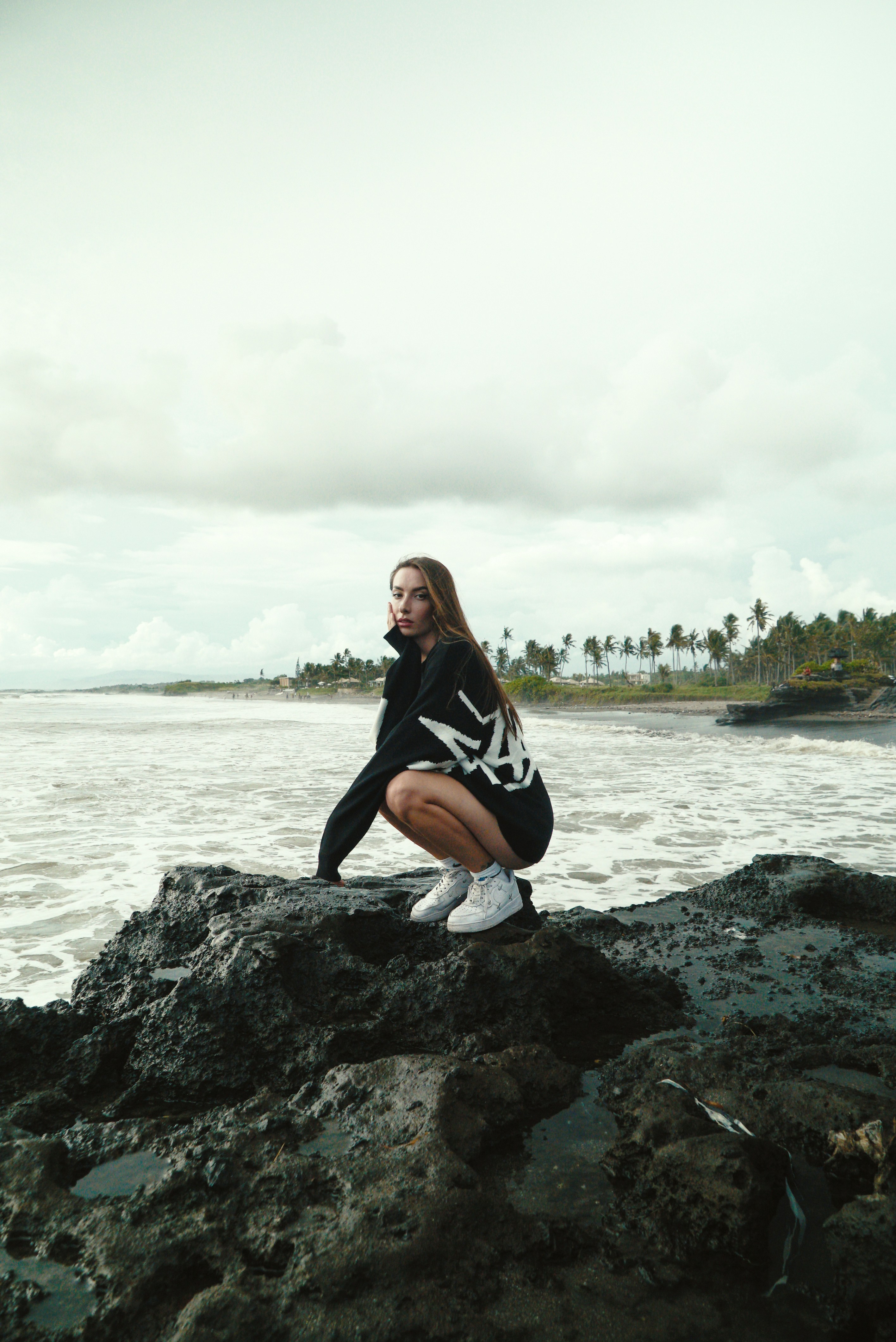 Squat on basalt: a solitary figure against a wind-swept shoreline