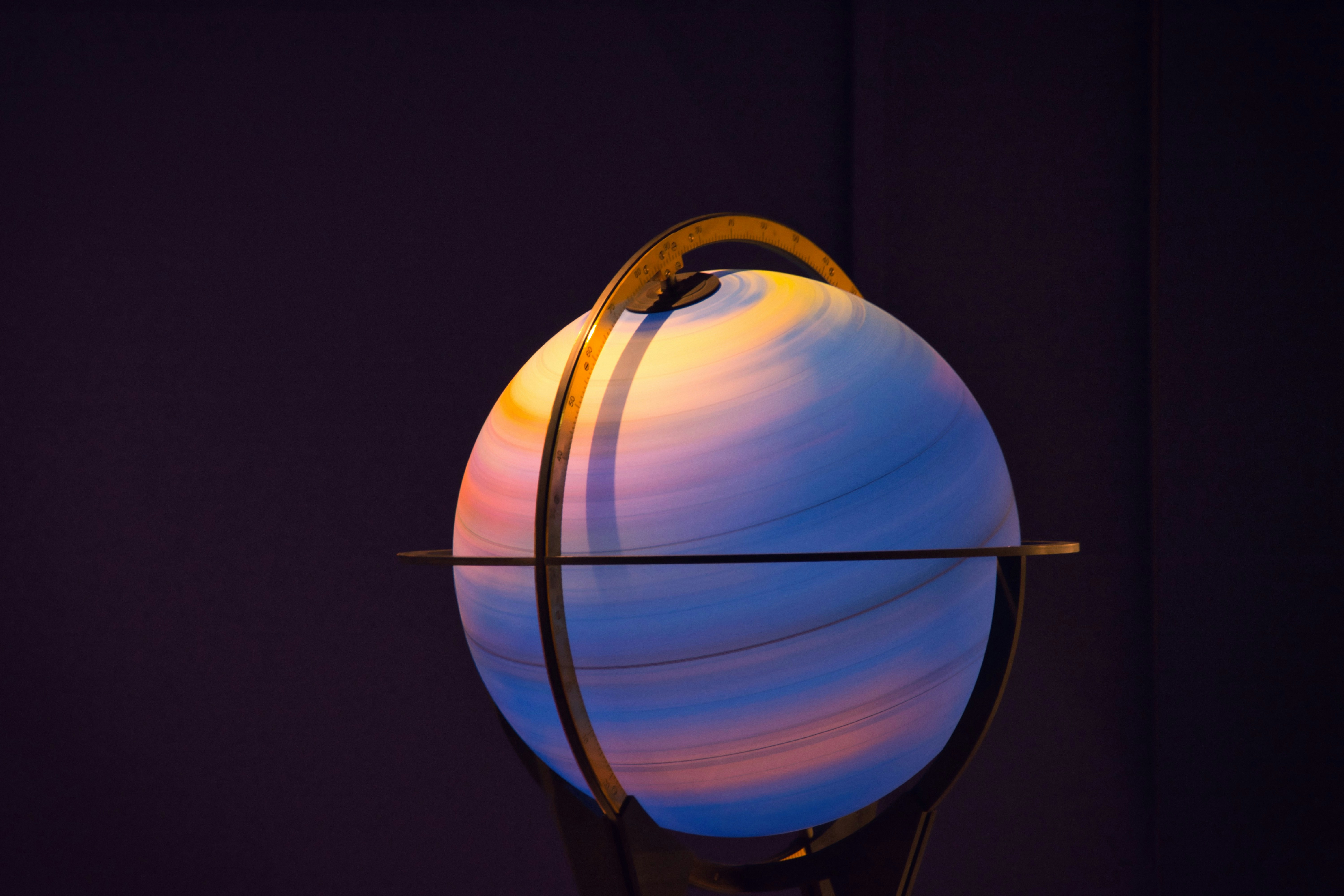 A spinning object on a stand in a dark room photo – Free Globe Image on ...