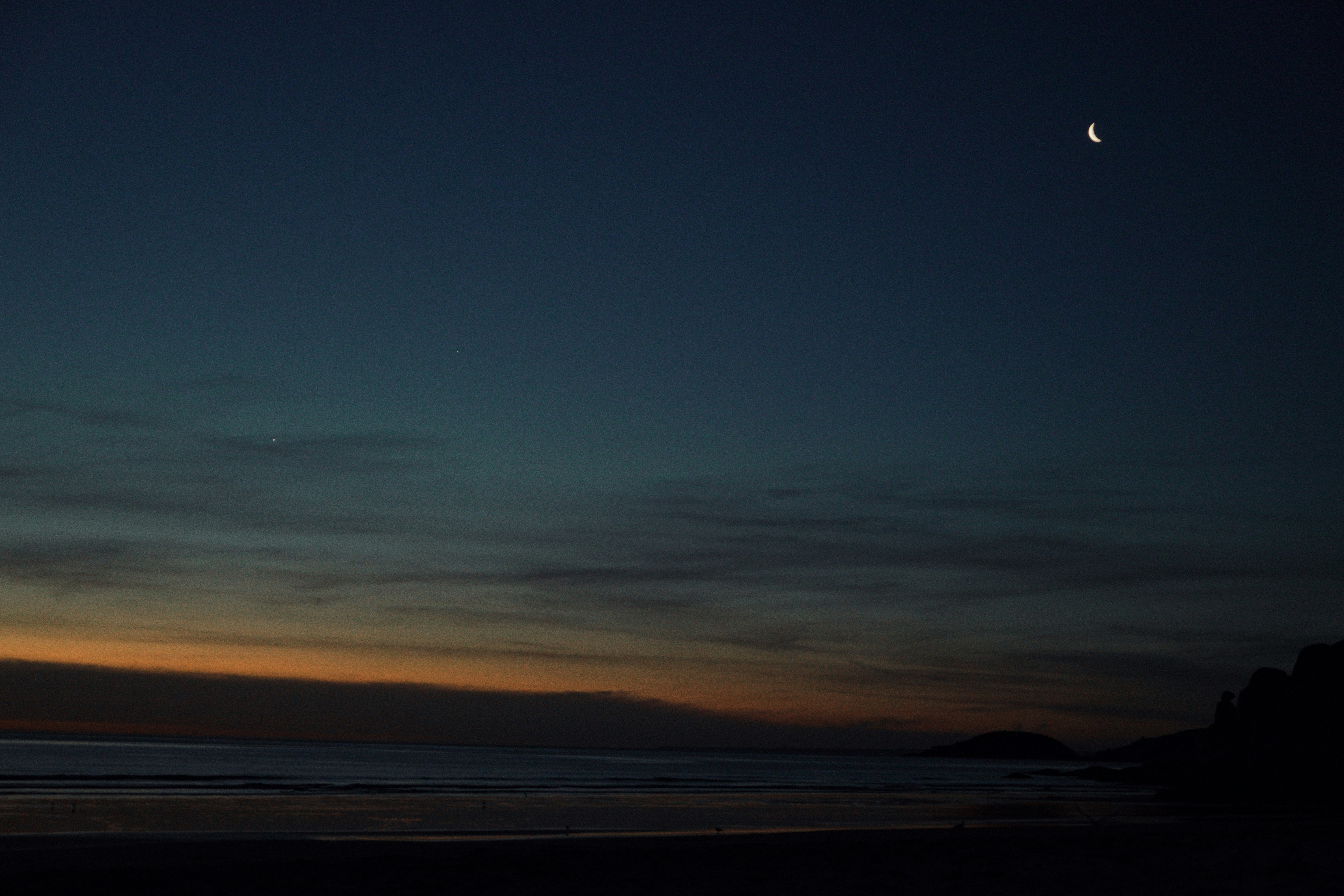 The moon is setting over the ocean on a cloudy day photo – Free Sky ...