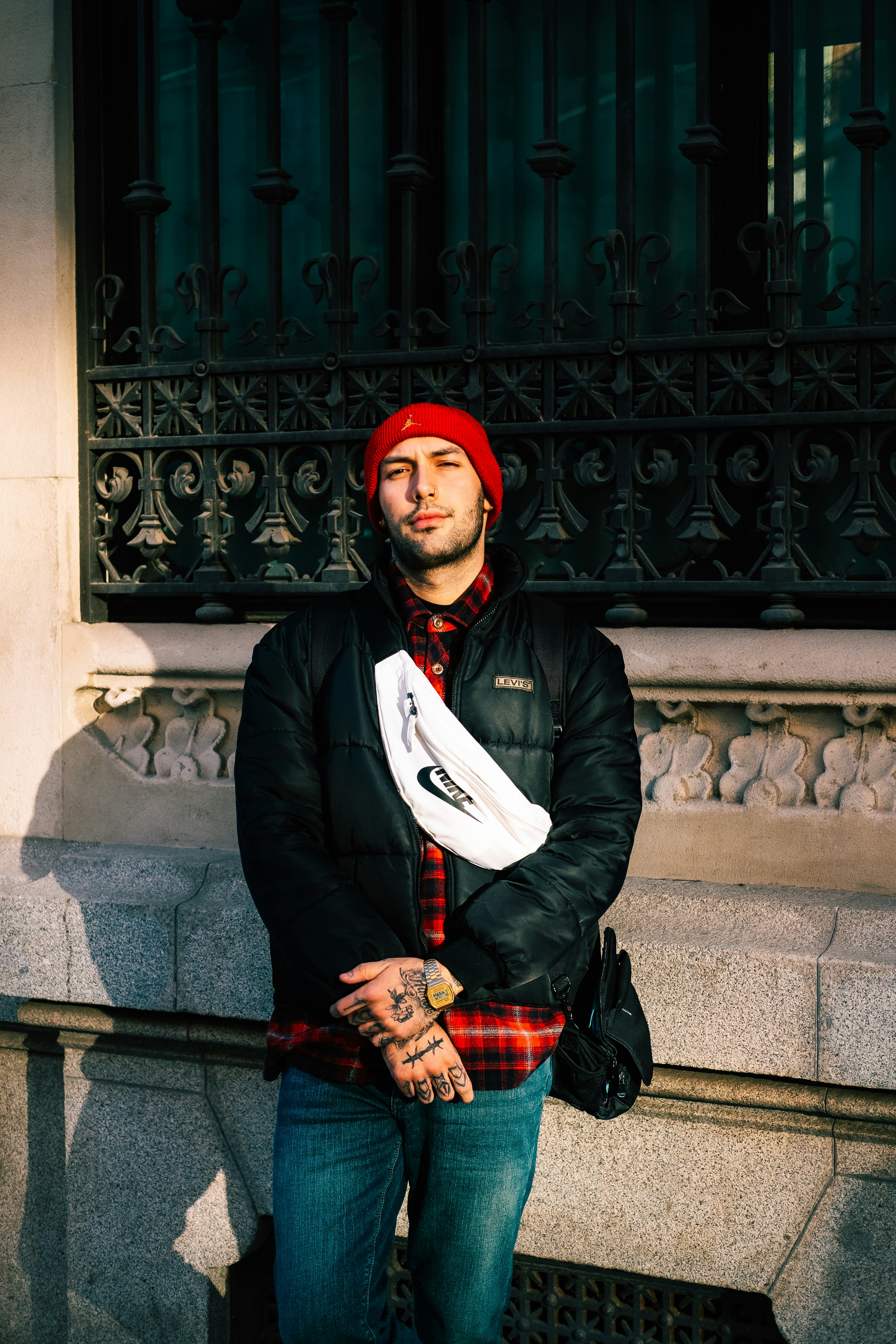 Crimson Beanie, Quiet Confidence by the Iron Gate