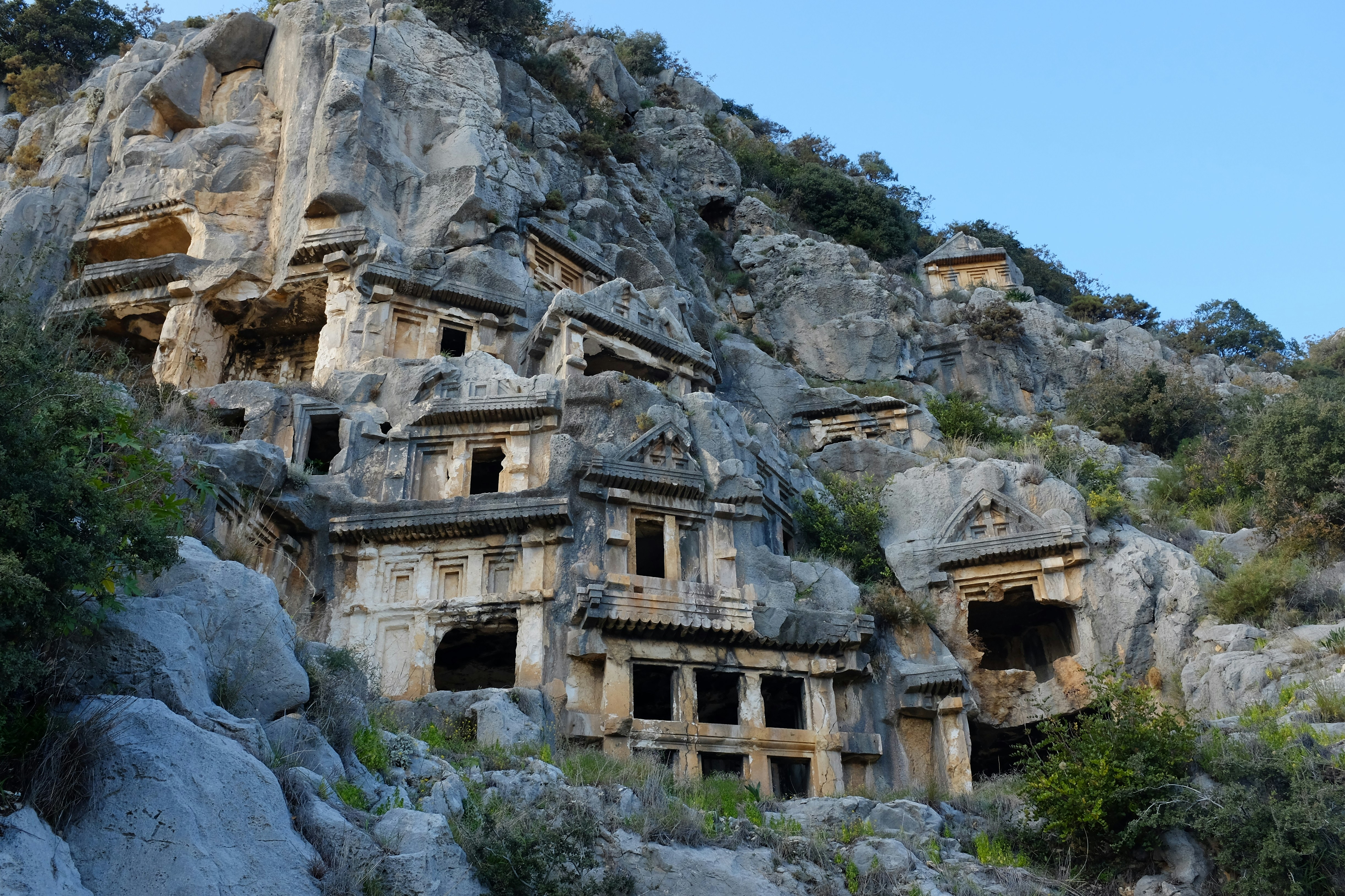 A group of buildings built into the side of a mountain photo – Free ...