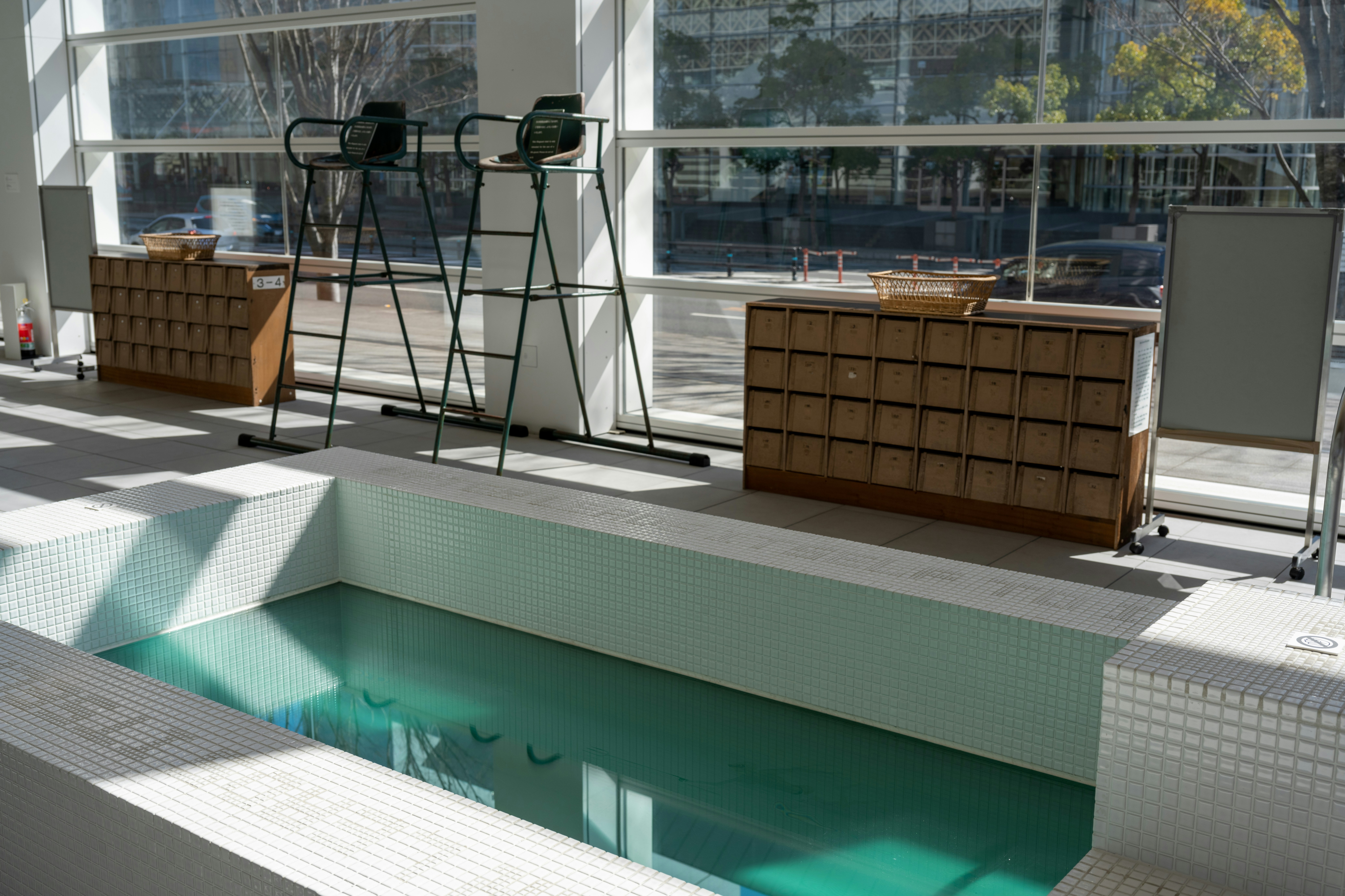 A swimming pool in a large building with windows photo – Free Car Image ...