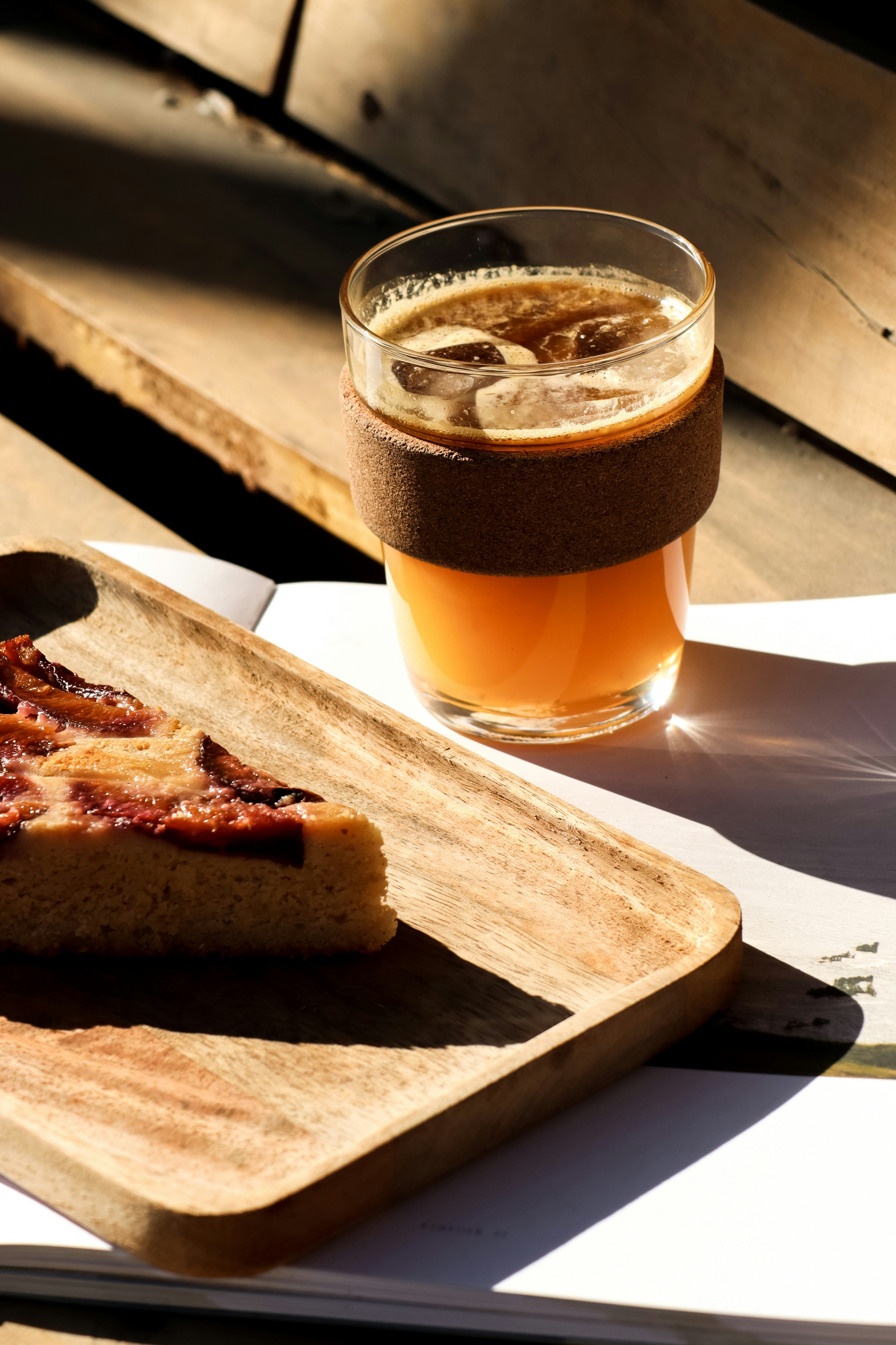 Amber Moment on Weathered Wood: Sunlit Drink and Cake Slice