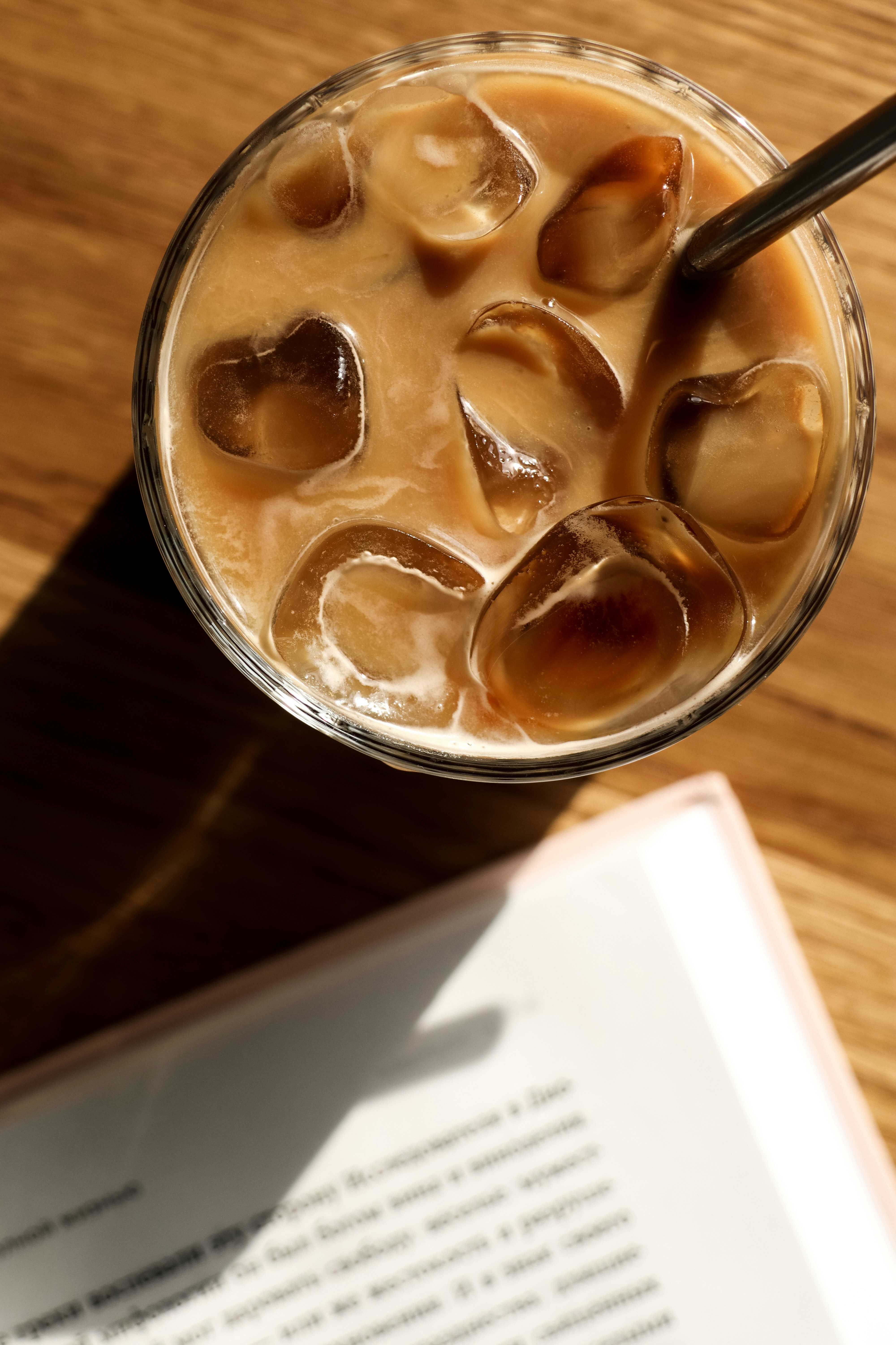 Top-Down Sip: Iced Coffee Among Pages