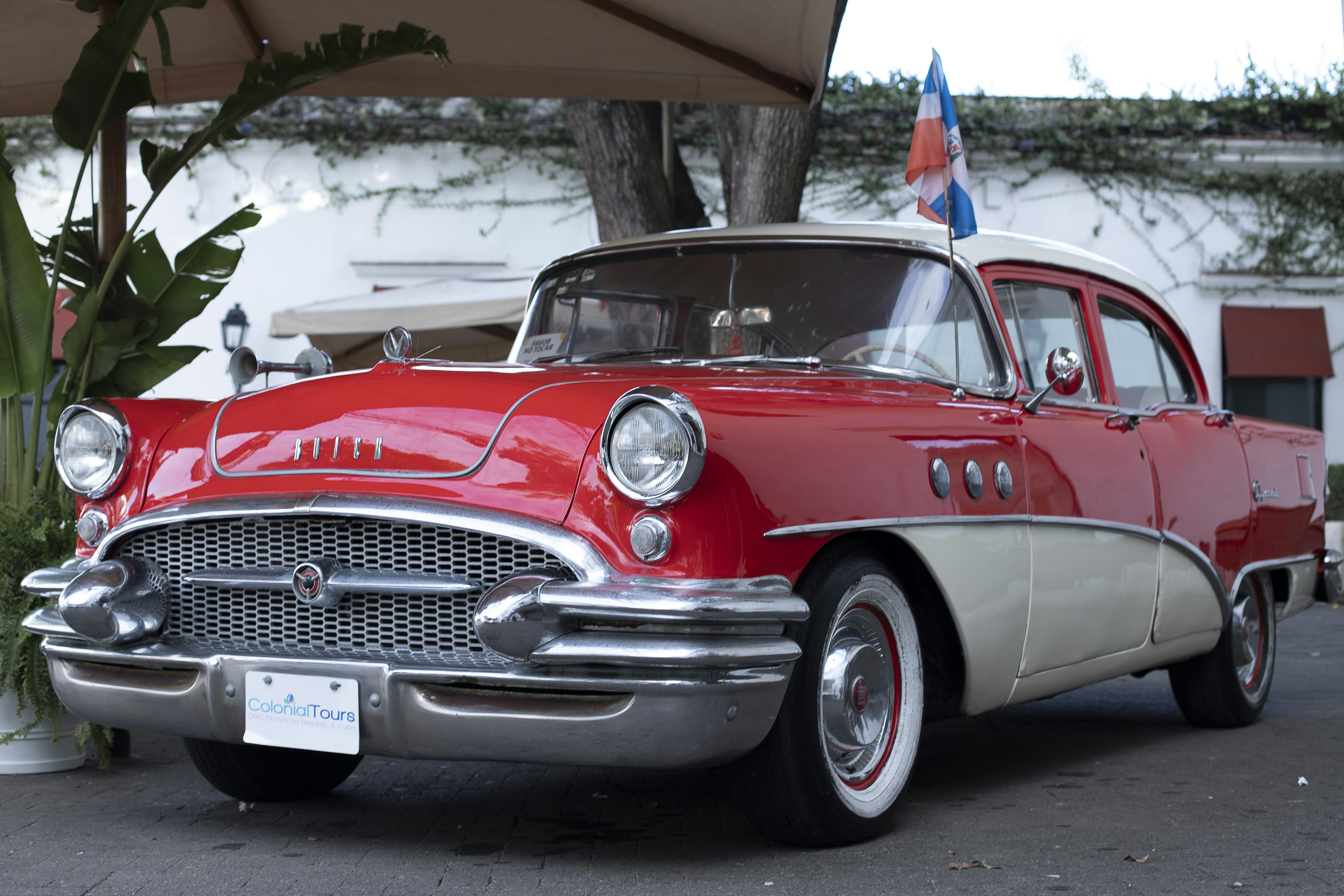 Crimson Chrome Classic: A 1950s Red Sedan Resting in the Shade