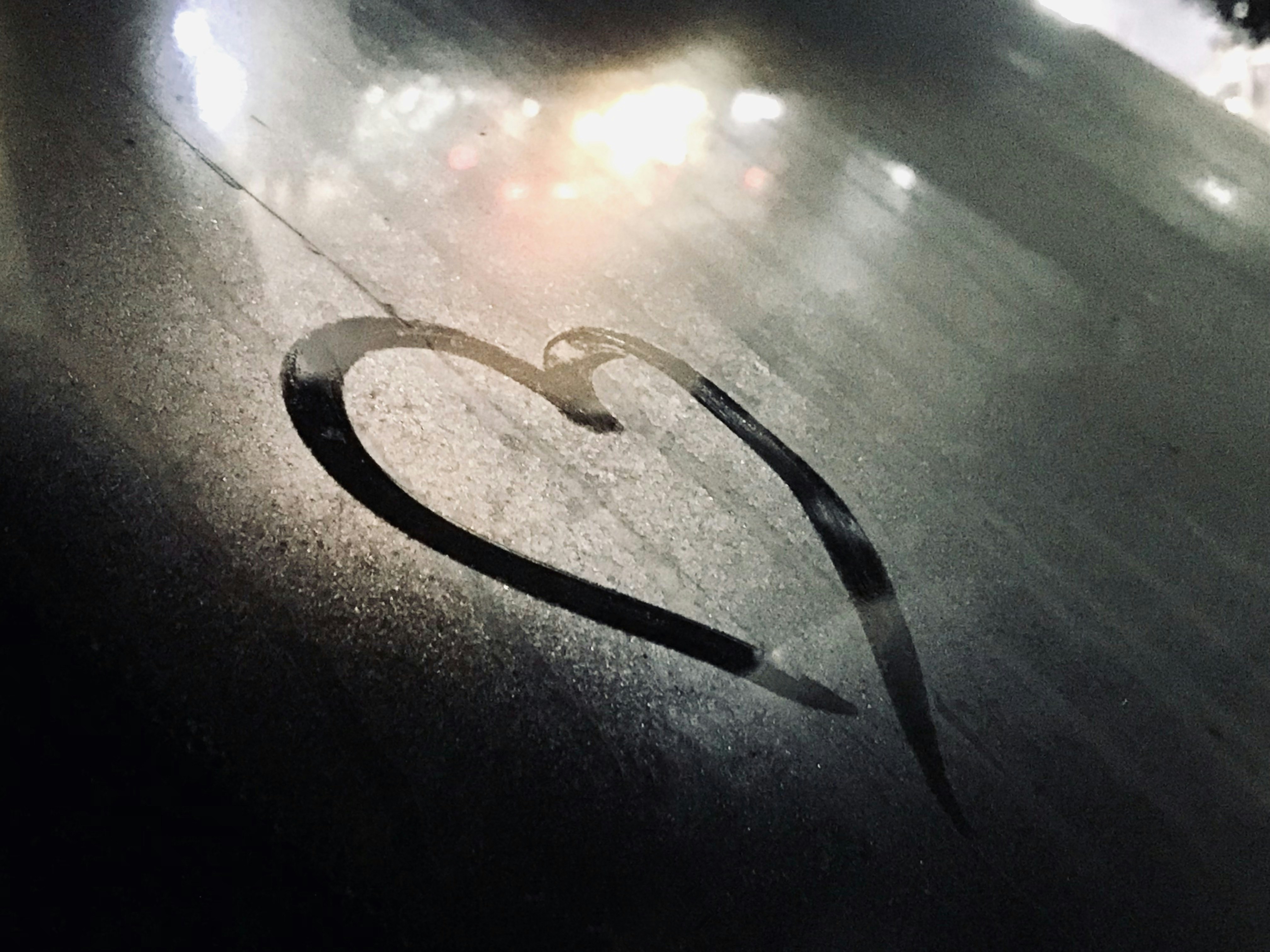 Heartmark on a Wet Car Surface Under Neon Glow