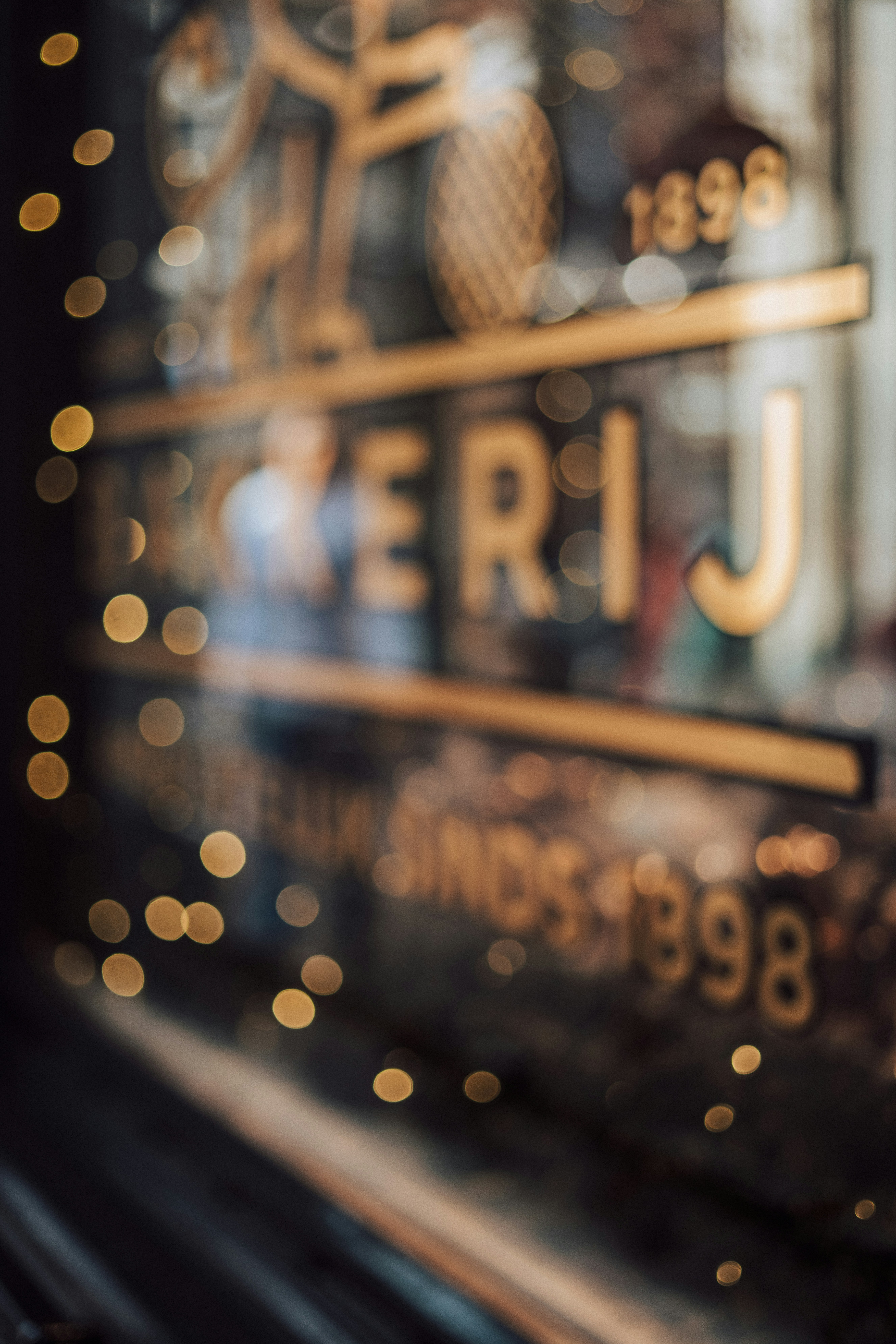 a close up of a glass window with lights in the background