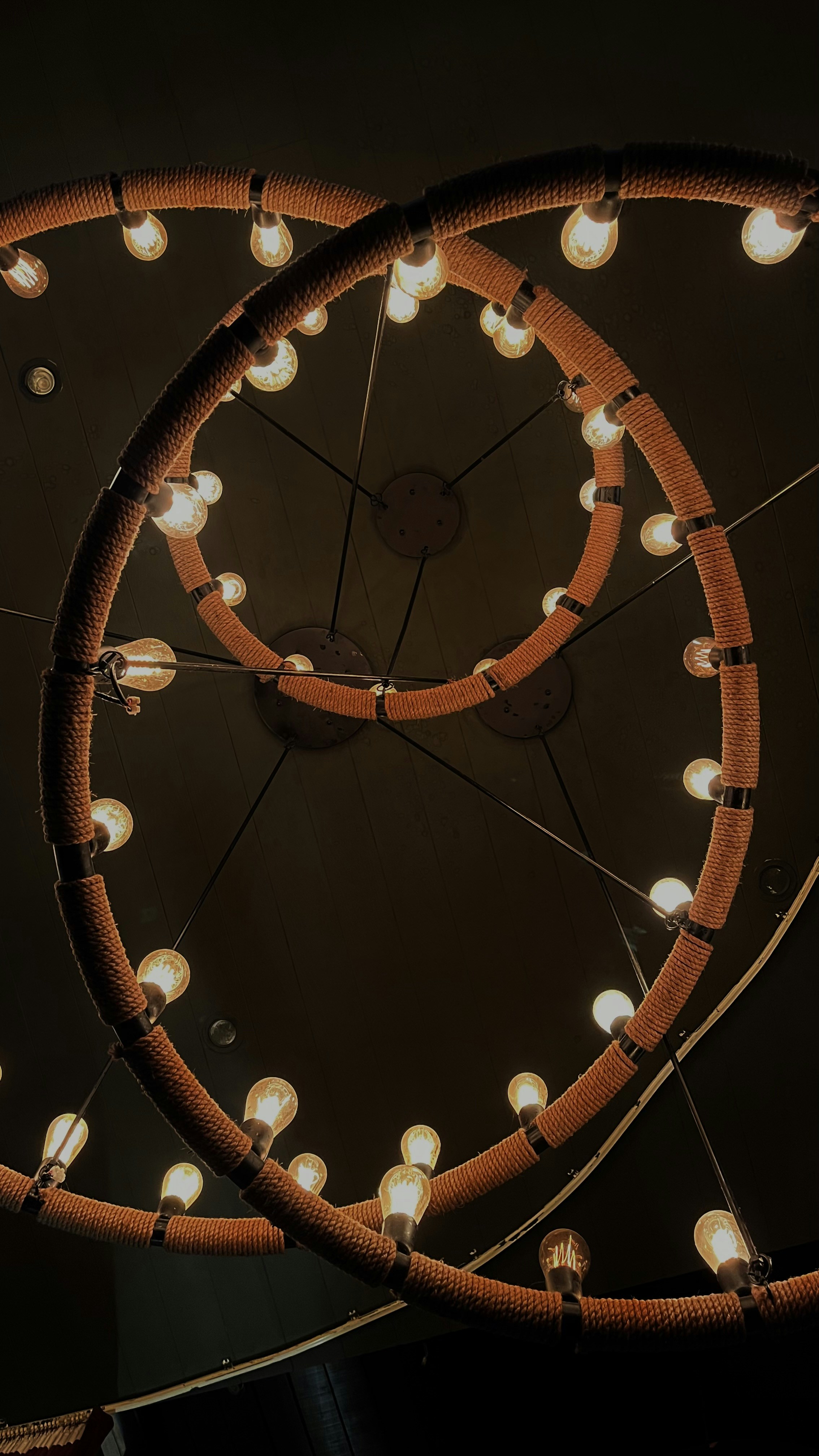 Orbital Glow: Rope-Wrapped Chandeliers Illuminating a Dark Ceiling