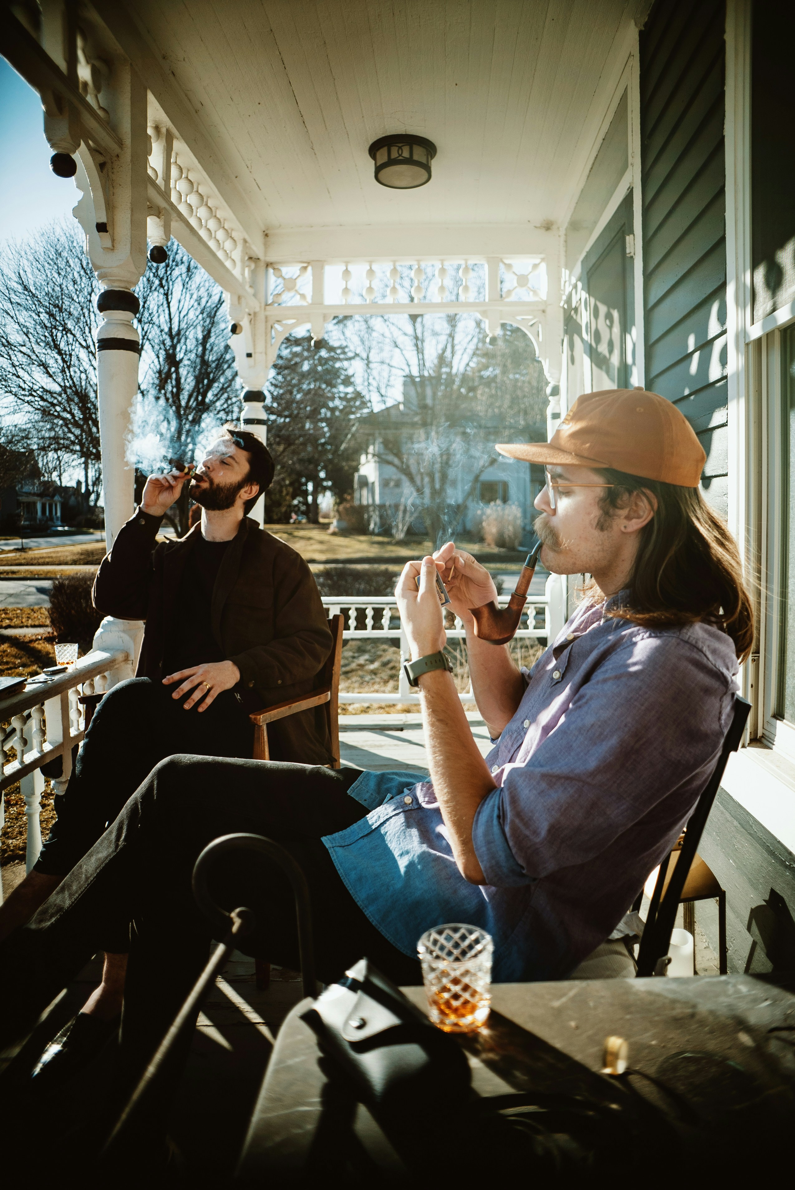 A man sitting on a porch smoking a cigarette photo – Free Porch Image ...