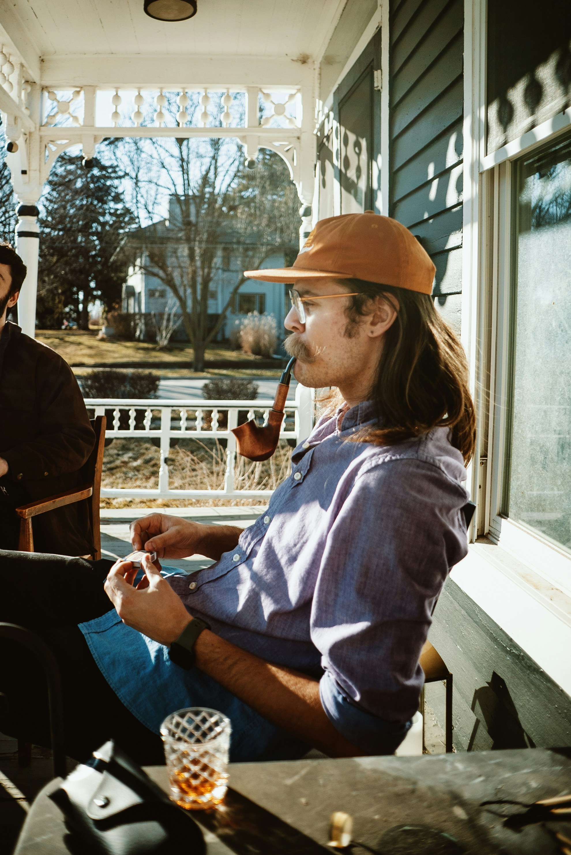 Porch Reverie: Sunlit Pause with a Pipe and Cap