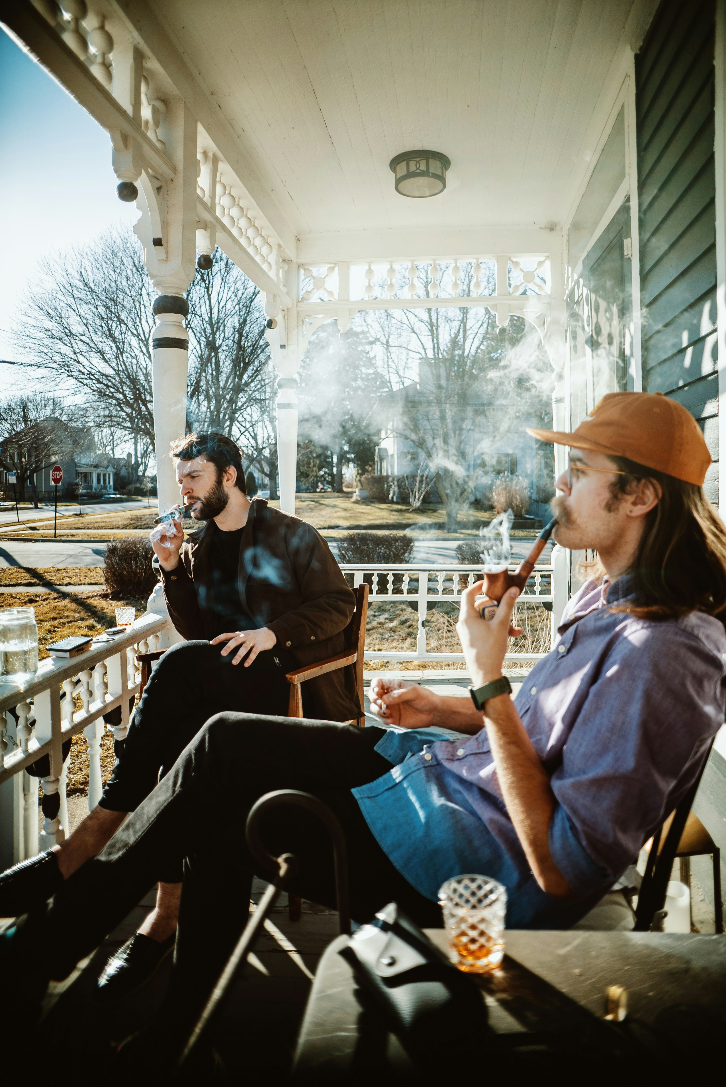 a couple of men sitting on top of a porch