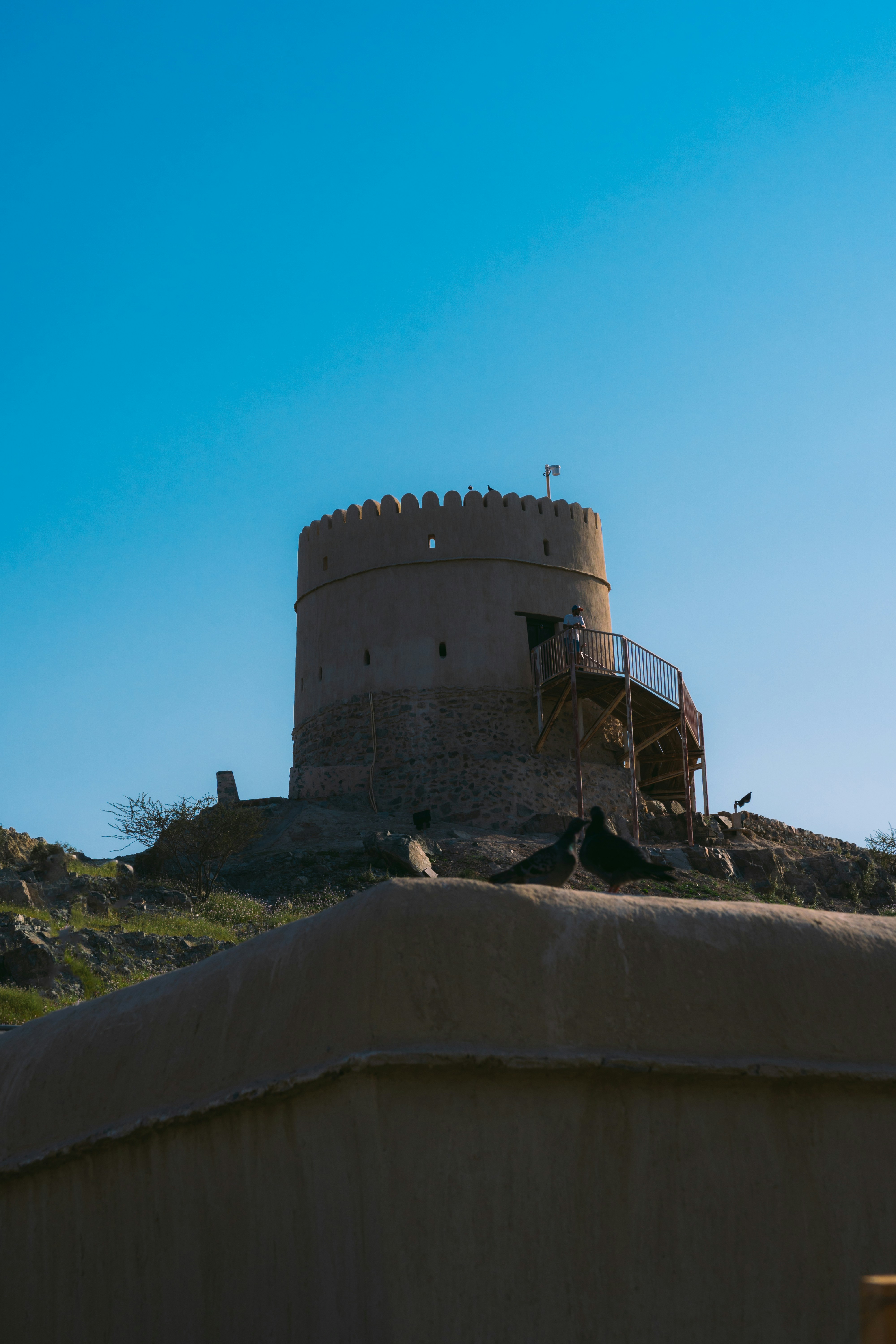Cerulean Sentinel: Hilltop Watchtower Against a Clear Blue Sky