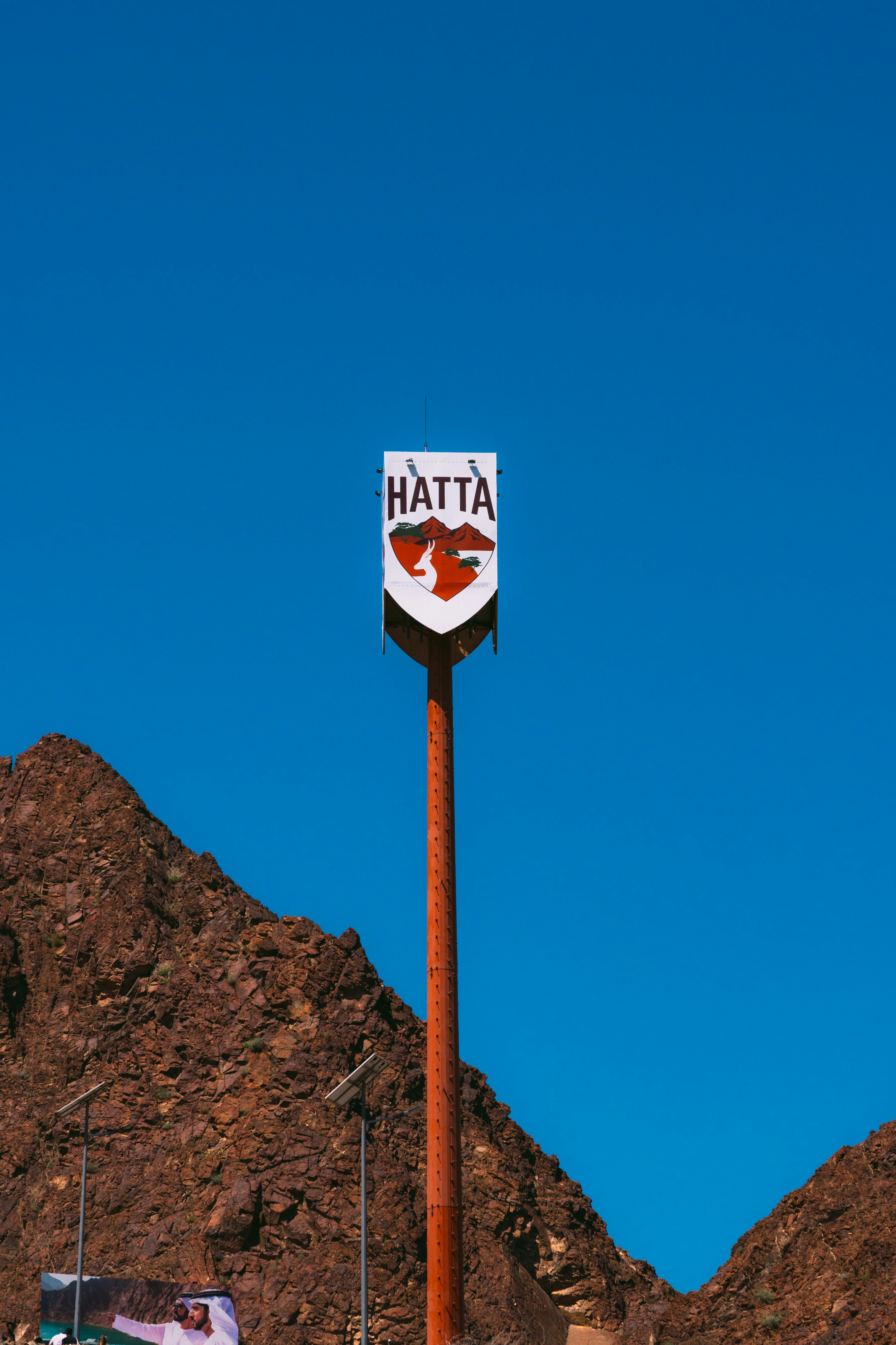 A tall red and white sign sitting on the side of a mountain photo ...